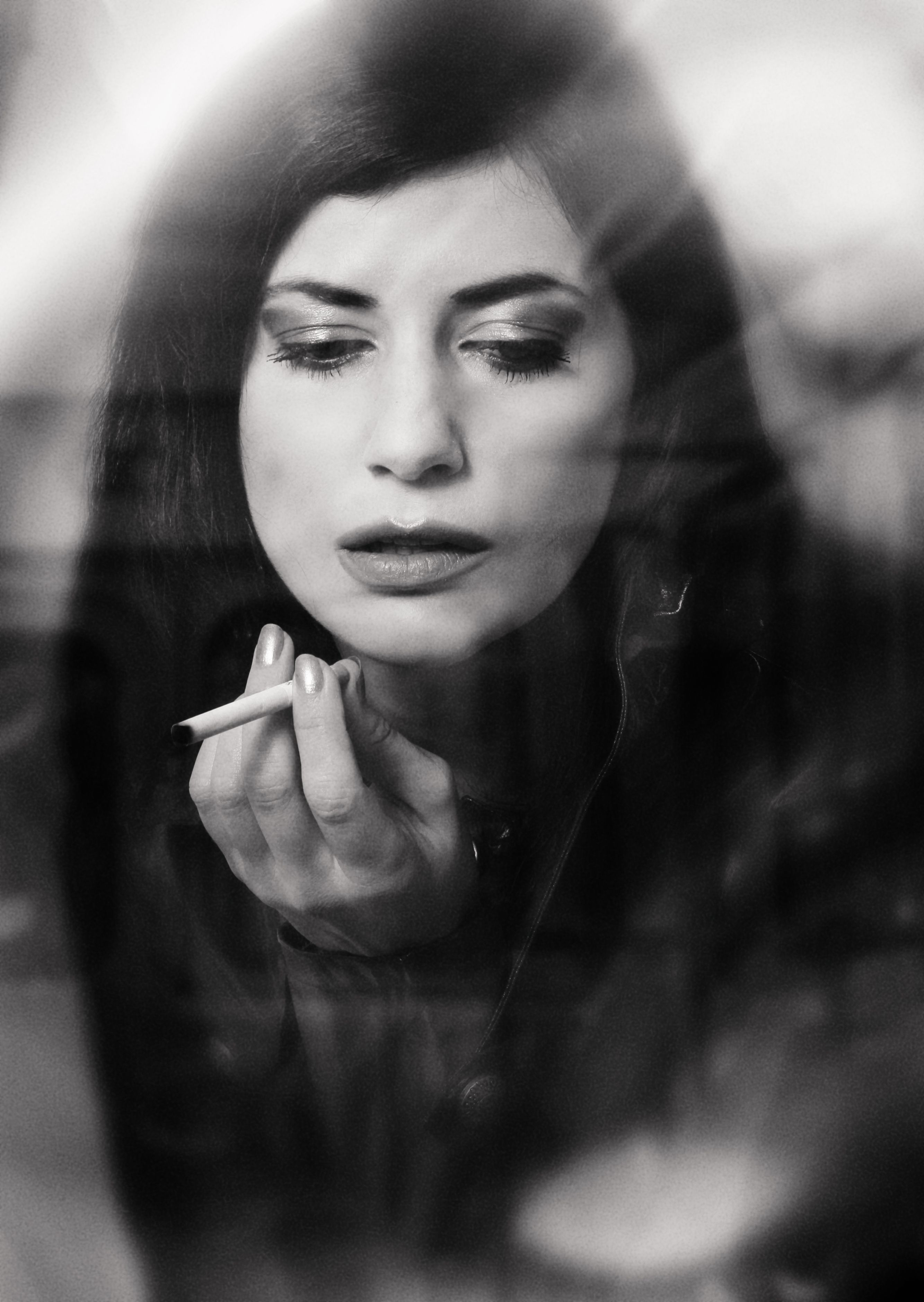 Pensive woman with makeup smoking cigarette · Free Stock Photo