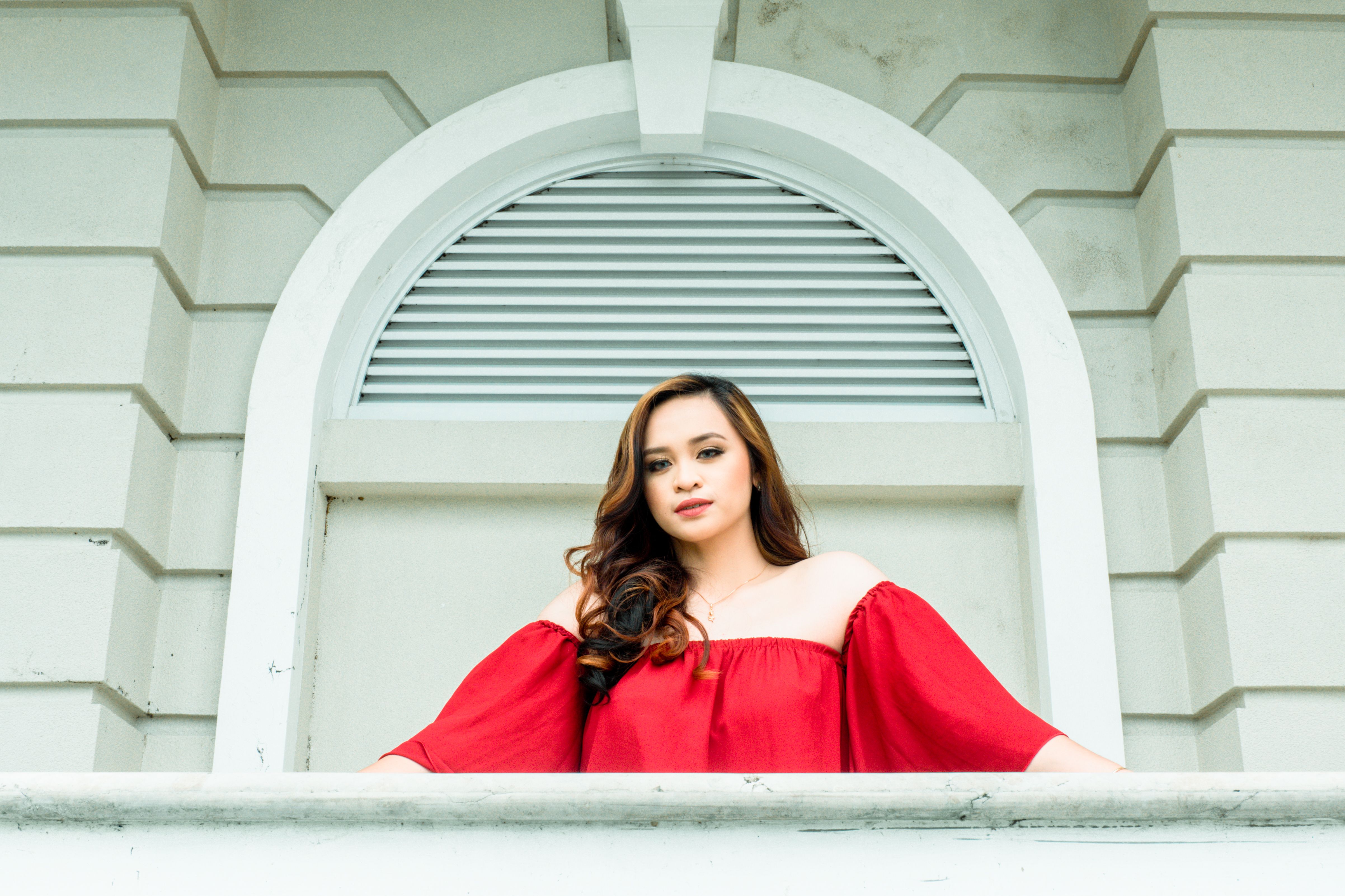 Woman in Red Dress Standing on a Balcony · Free Stock Photo