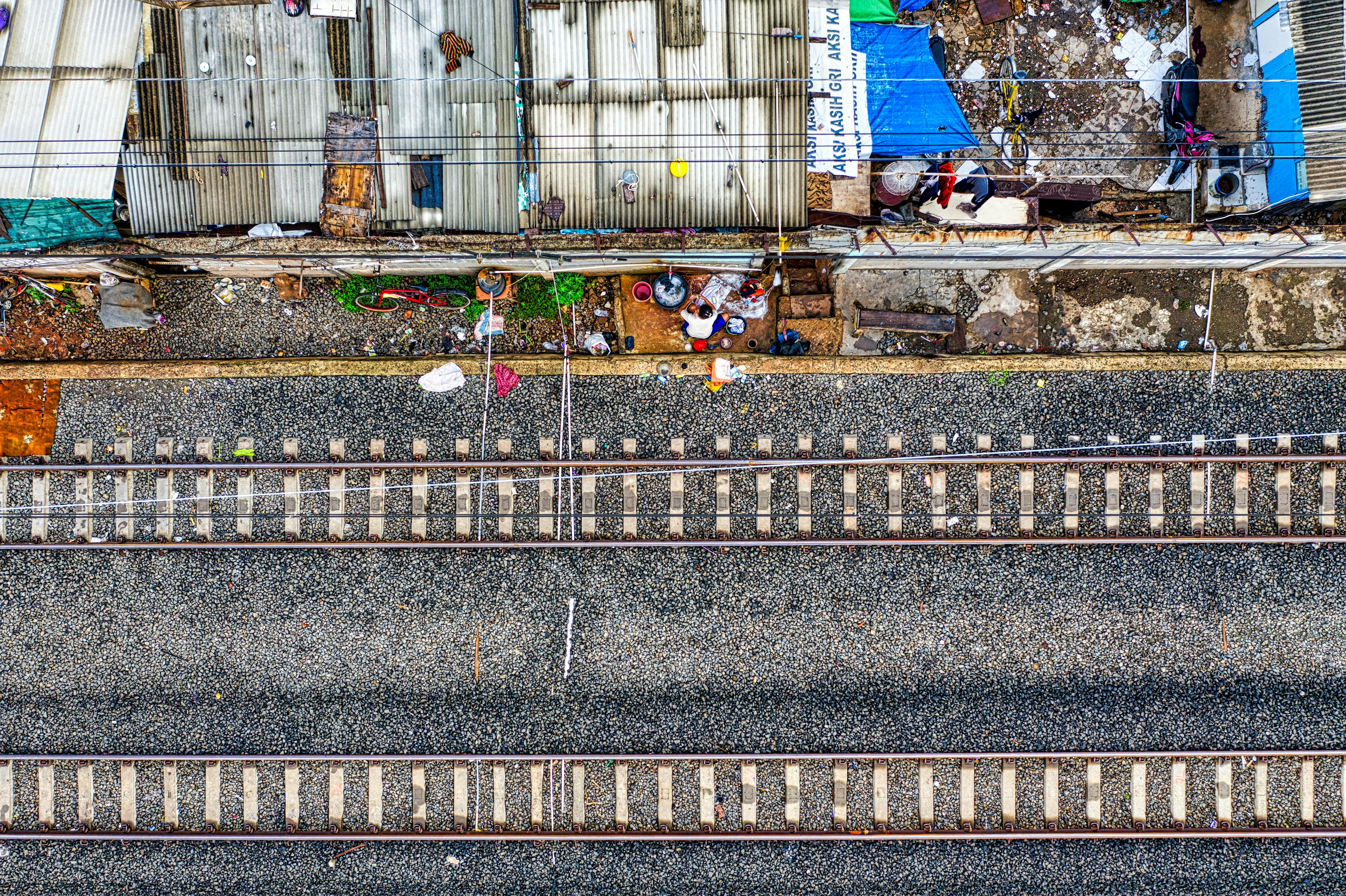An Aerial View of a Double Train Tracks on Gray Road Near Houses · Free ...