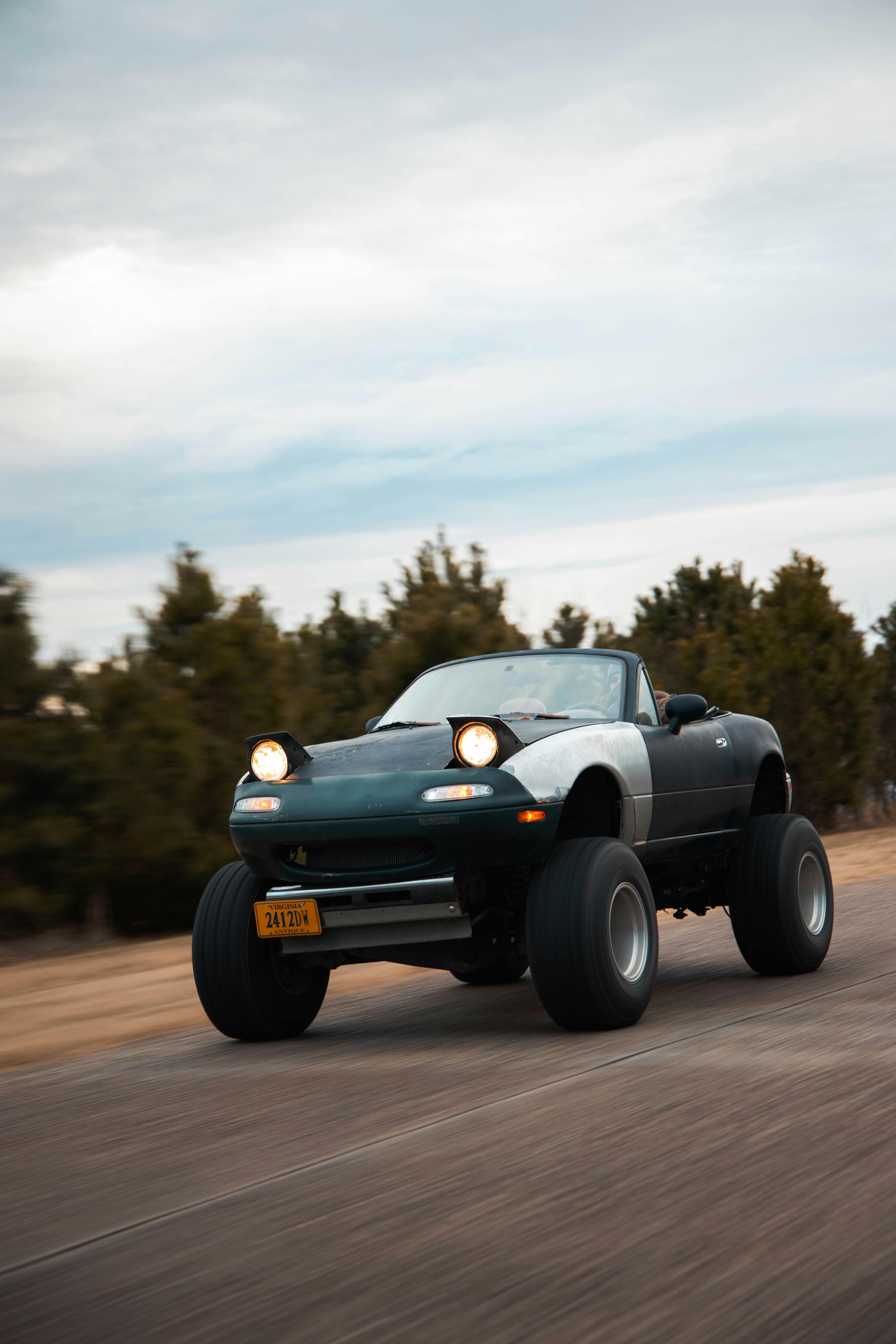 A Customized Car Driving on Asphalt Road · Free Stock Photo