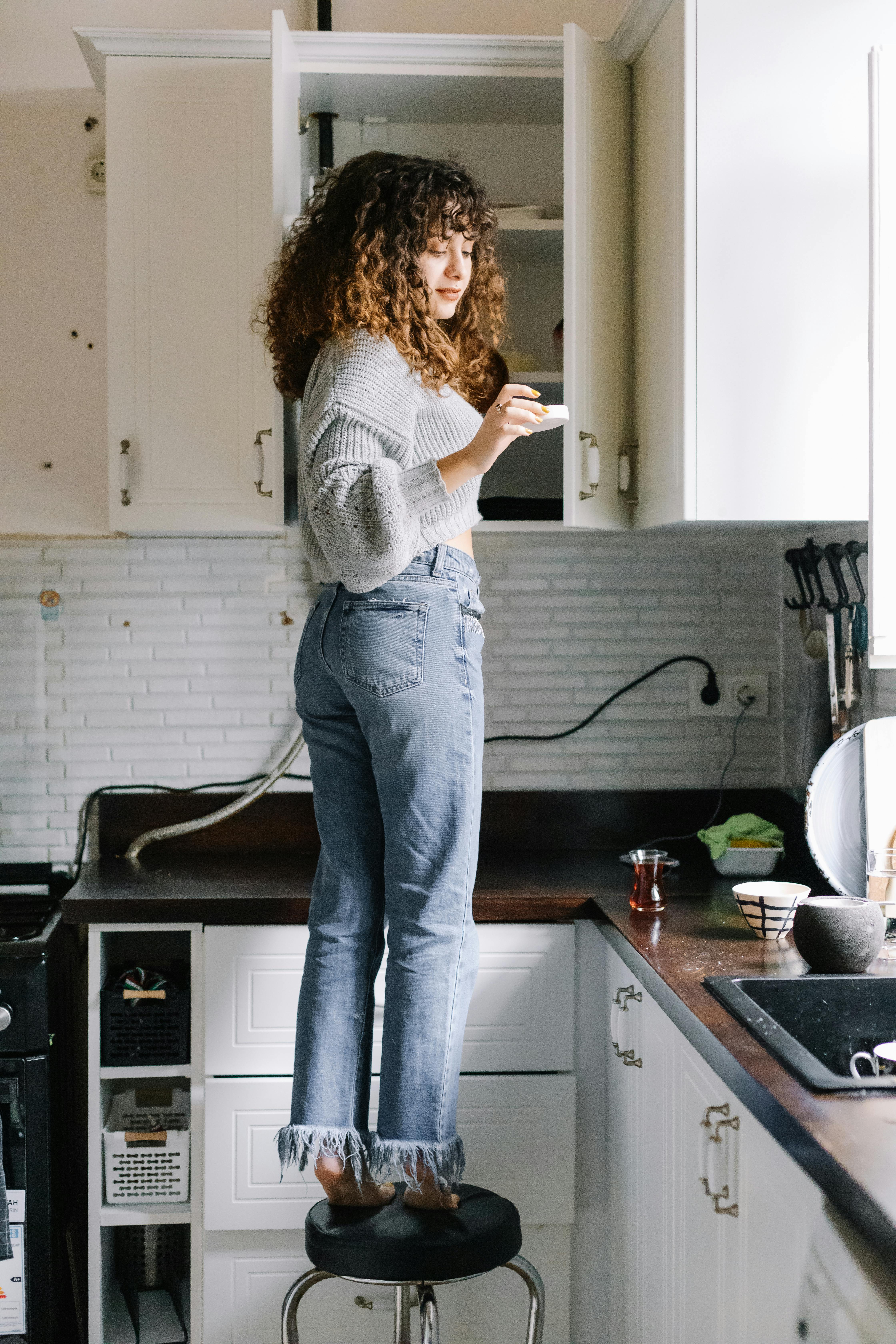 Photo of a Woman Standing on a Chair · Free Stock Photo