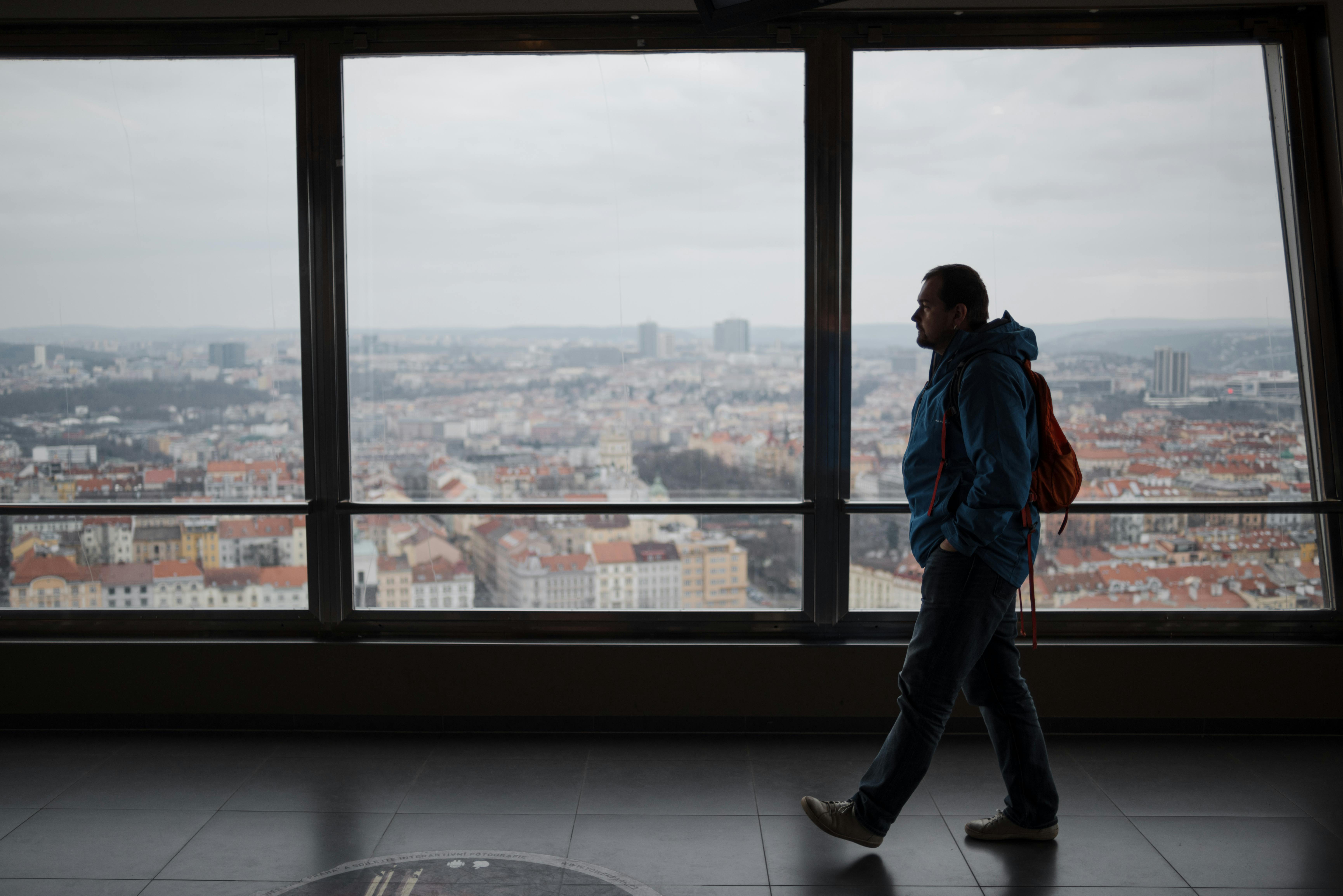 Man walking along windows in modern building · Free Stock Photo