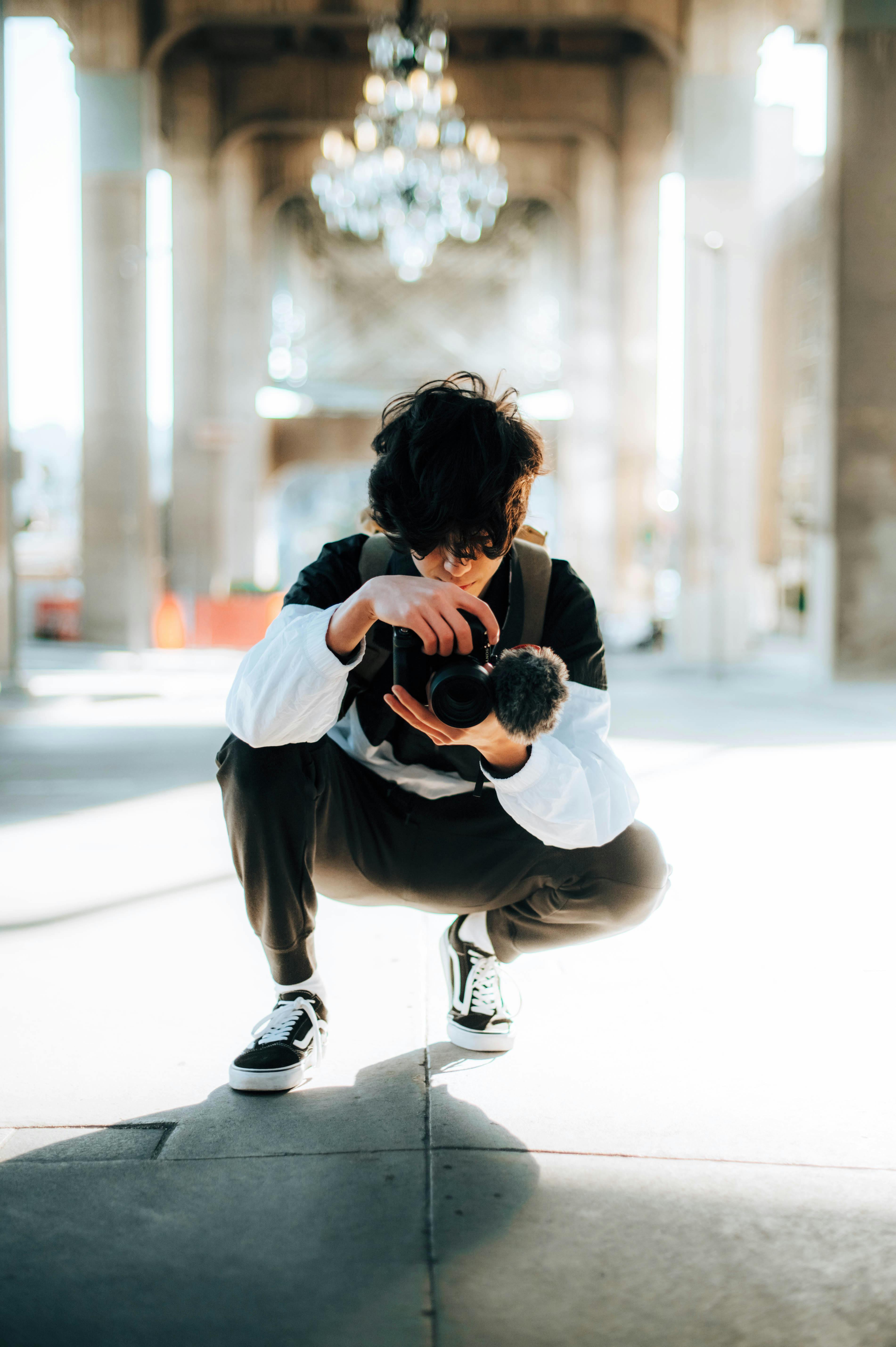Man Sitting on a Chair and Holding a Camera · Free Stock Photo