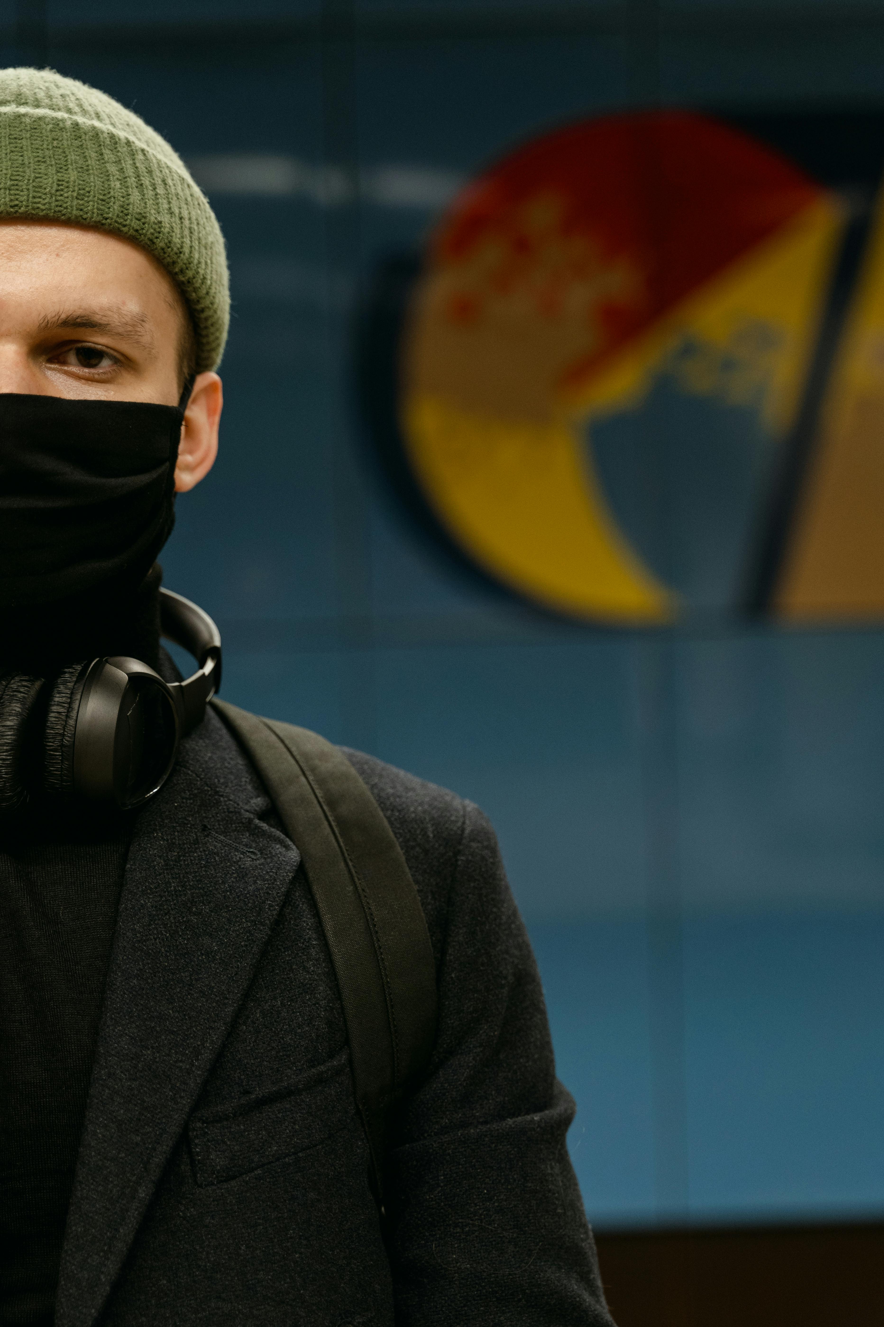 A Man in a Black Coat Wearing a Face Mask · Free Stock Photo