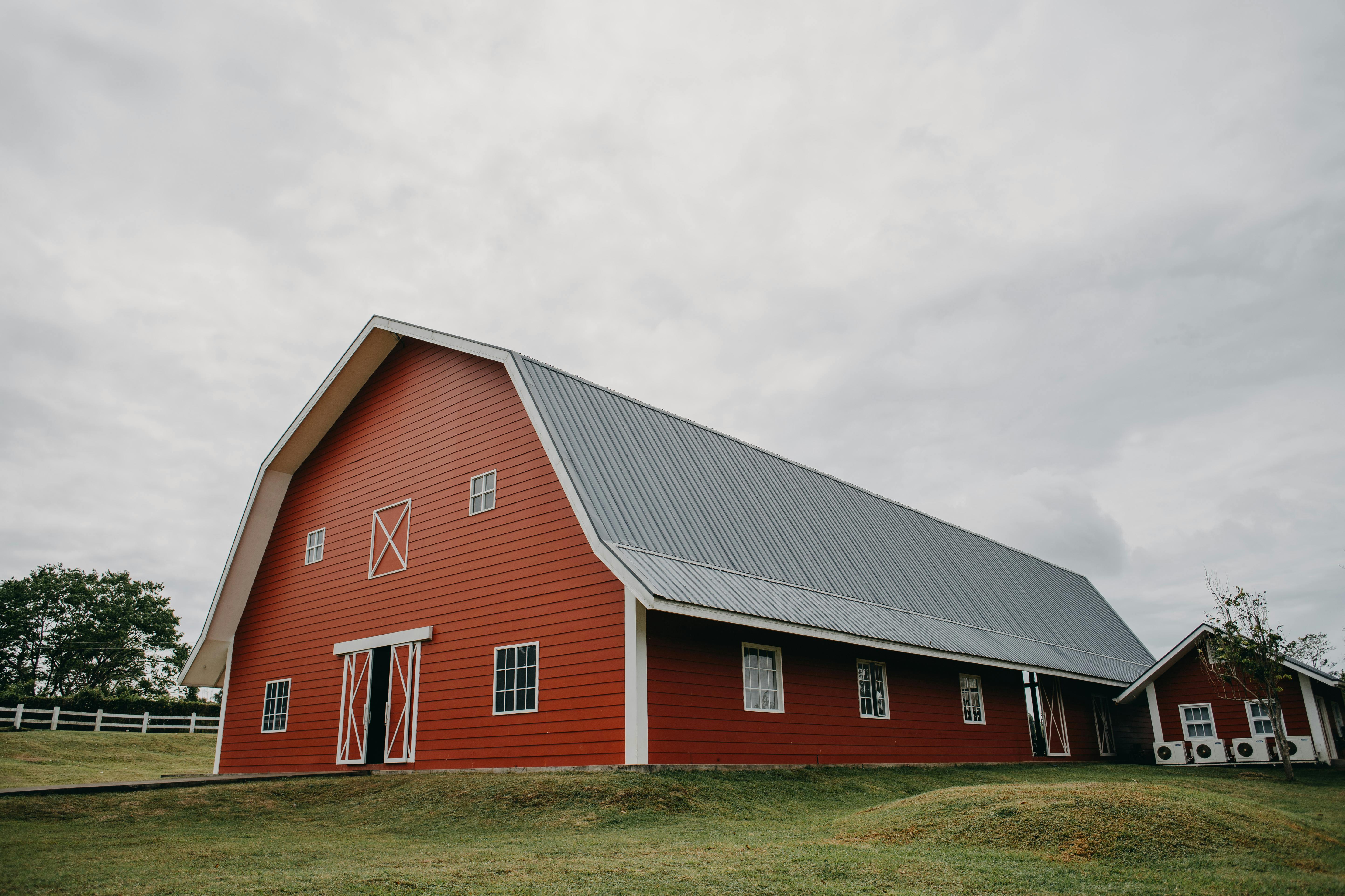 Photo of Red Farm Buildings Against a Cloudy Sky · Free Stock Photo
