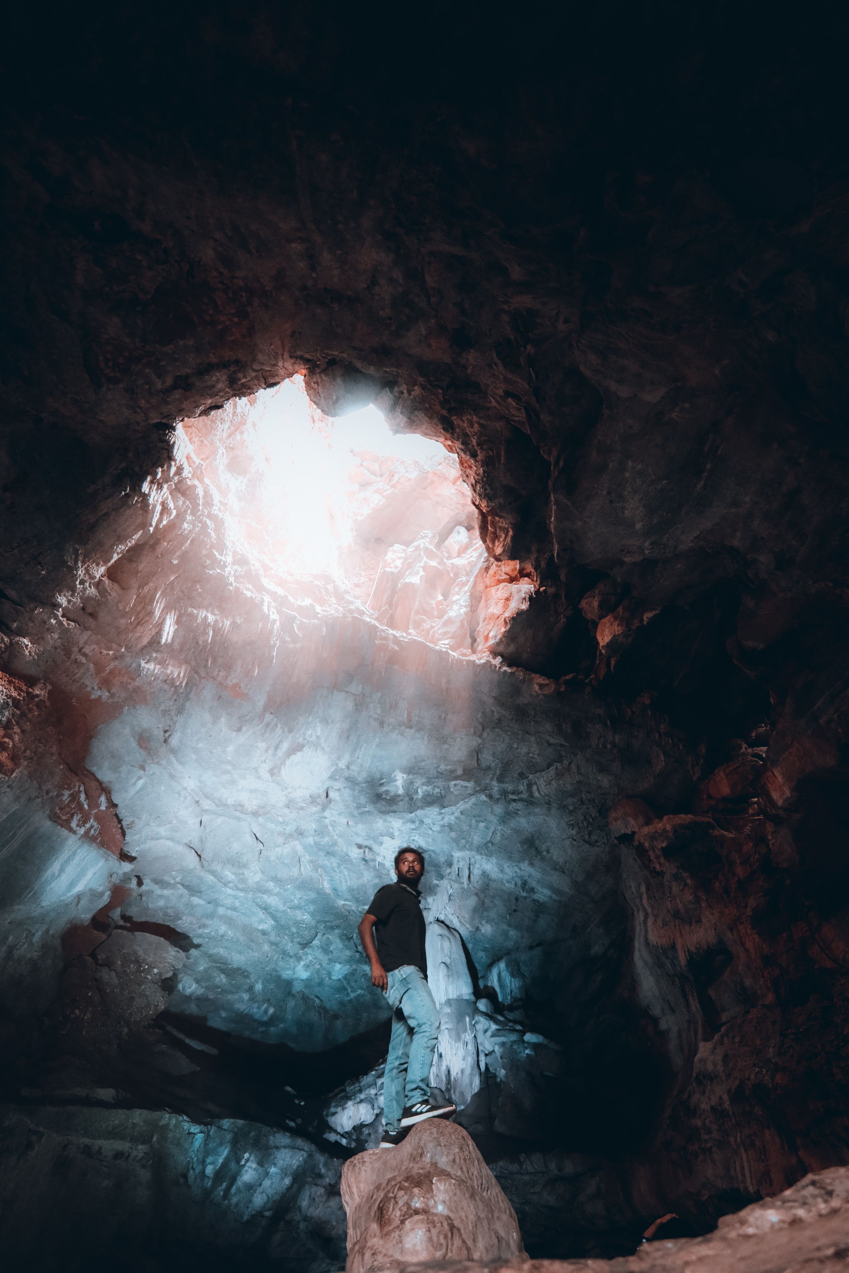 Photo Of Man Sitting Inside Cavee · Free Stock Photo