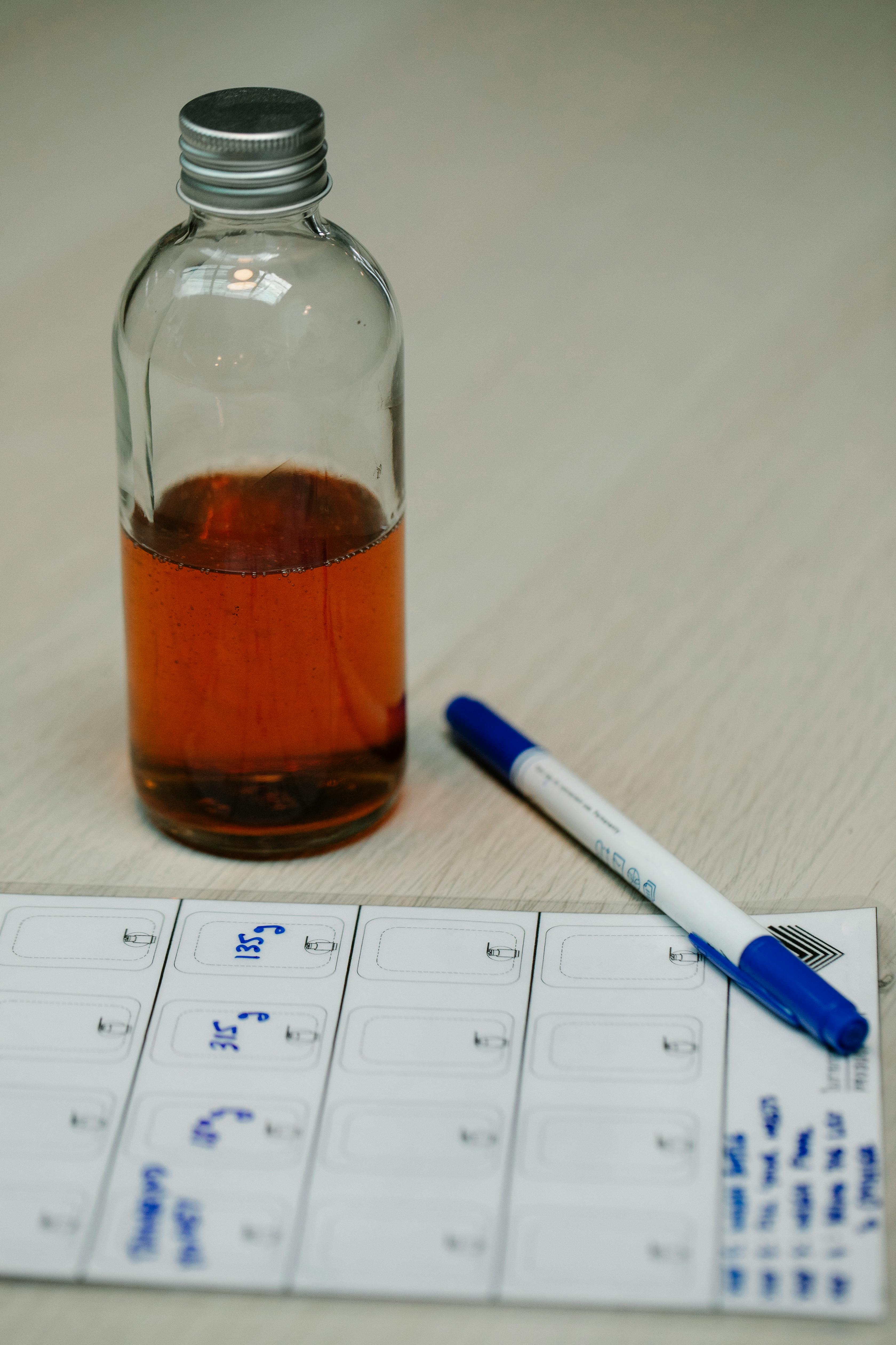 Glass Bottle with Lab Specimen on Table · Free Stock Photo