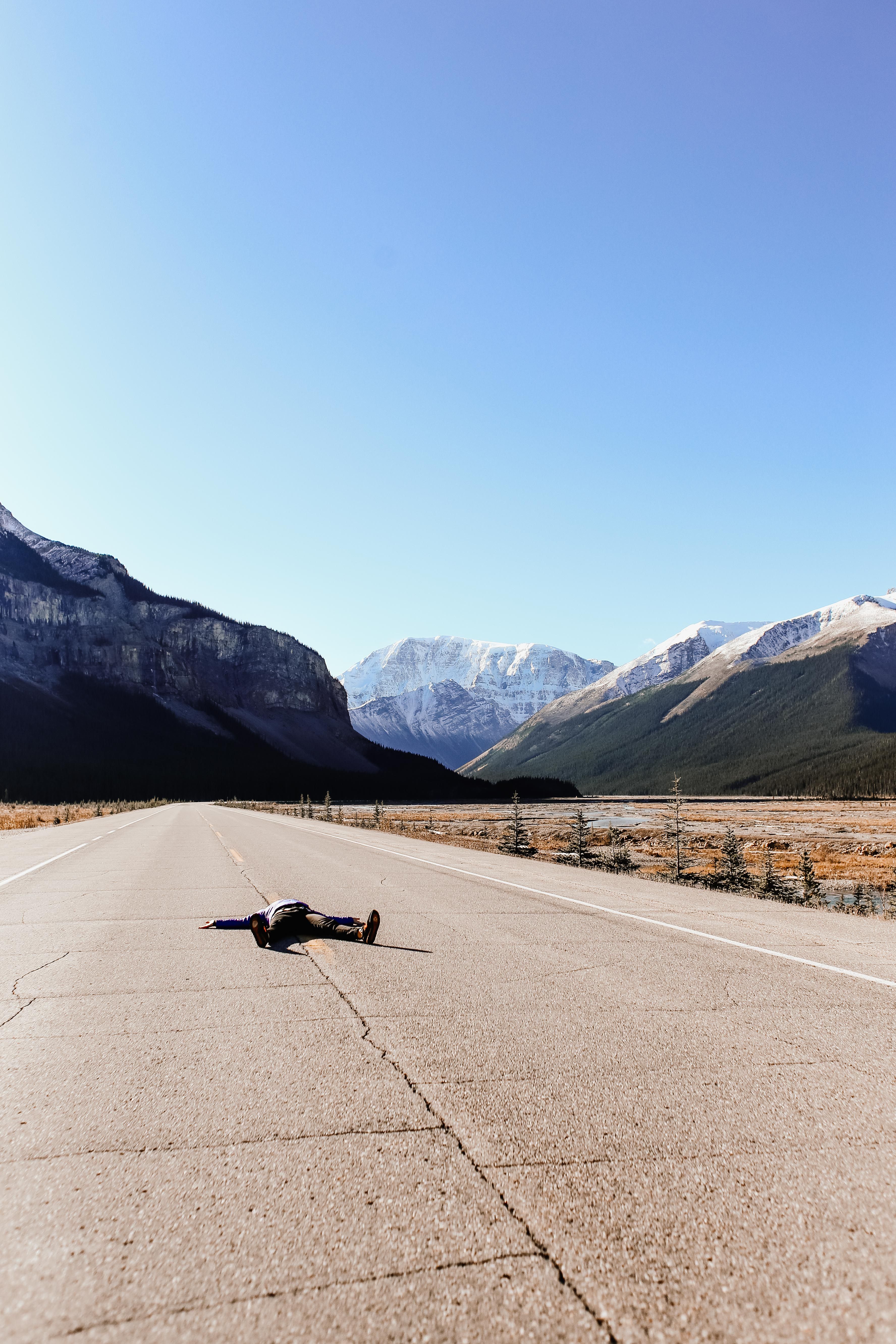 Person Lying in the Middle of the Road · Free Stock Photo
