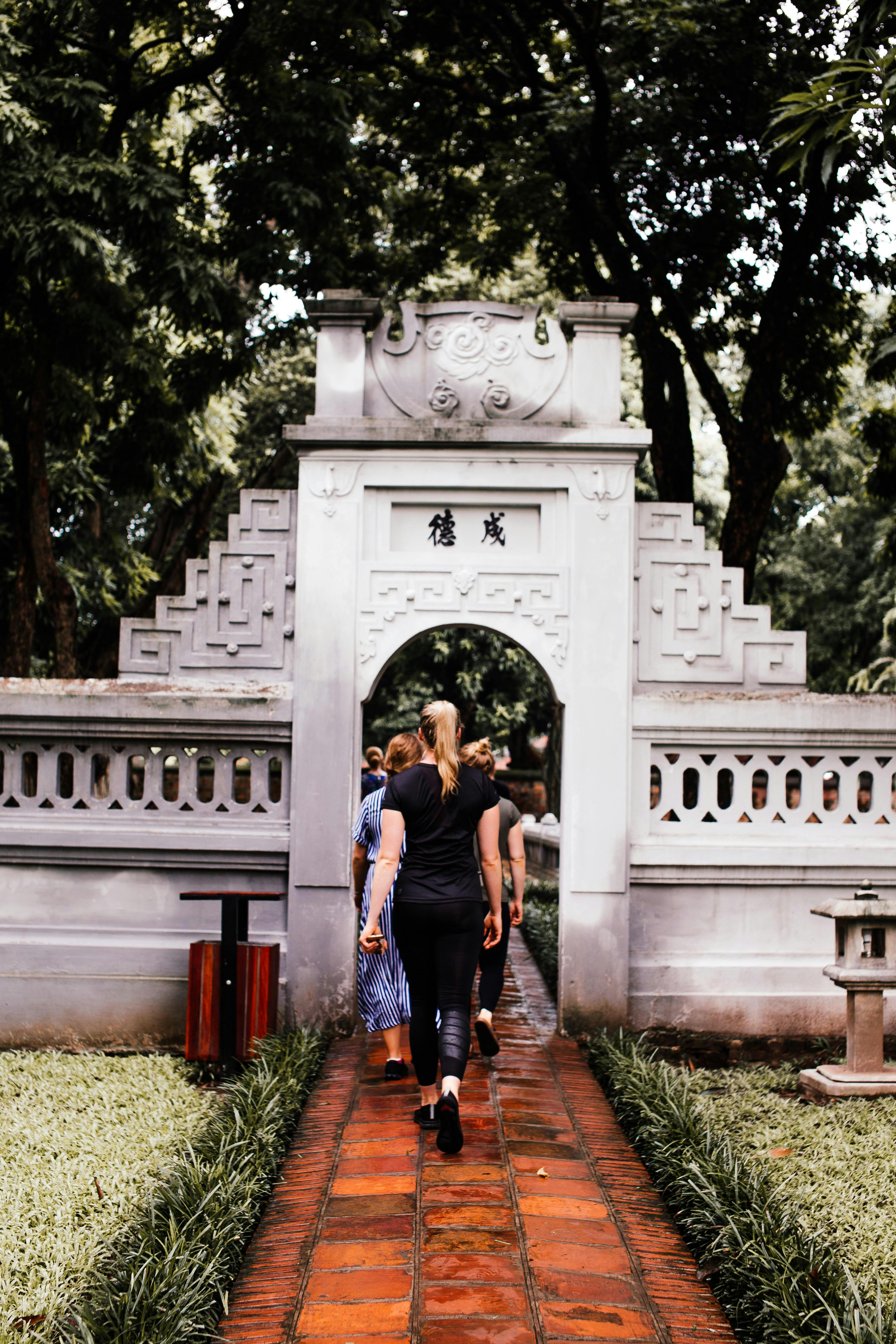 People Walking Through a Gate in a Park · Free Stock Photo