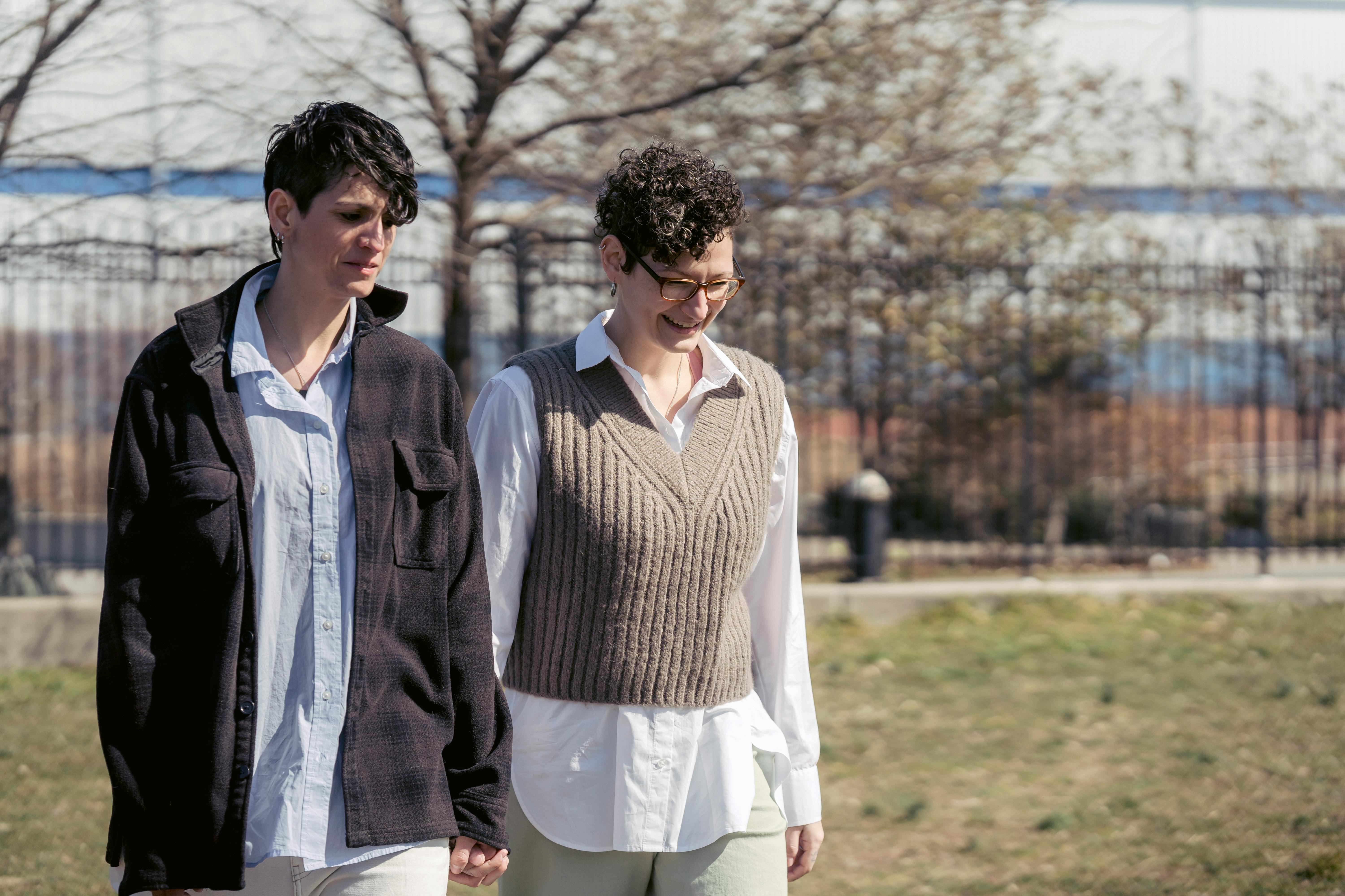 Positive androgynous friends walking on urban street · Free Stock Photo