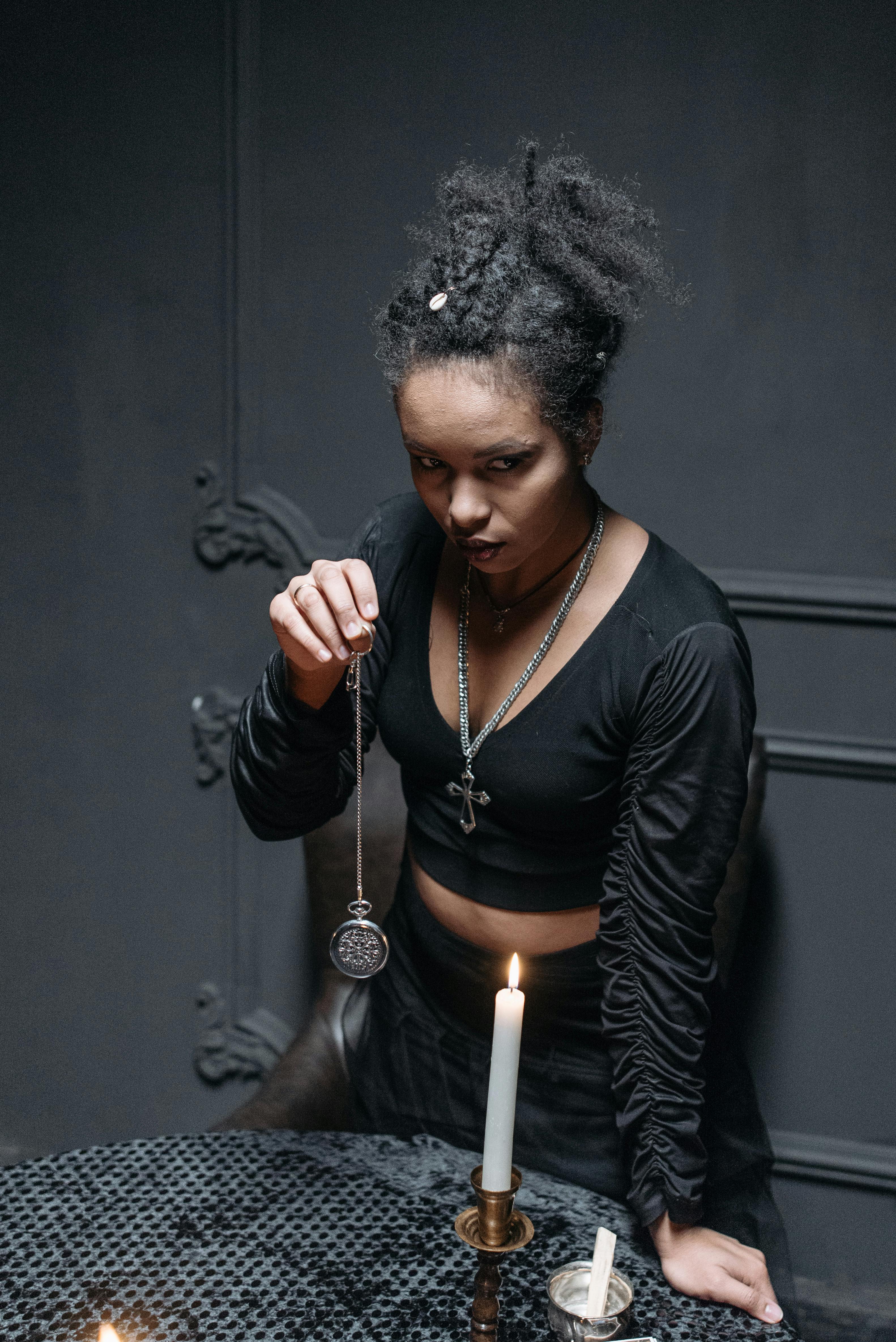 A Woman in Black Long Sleeve Crop Top Holding a Locket · Free Stock Photo