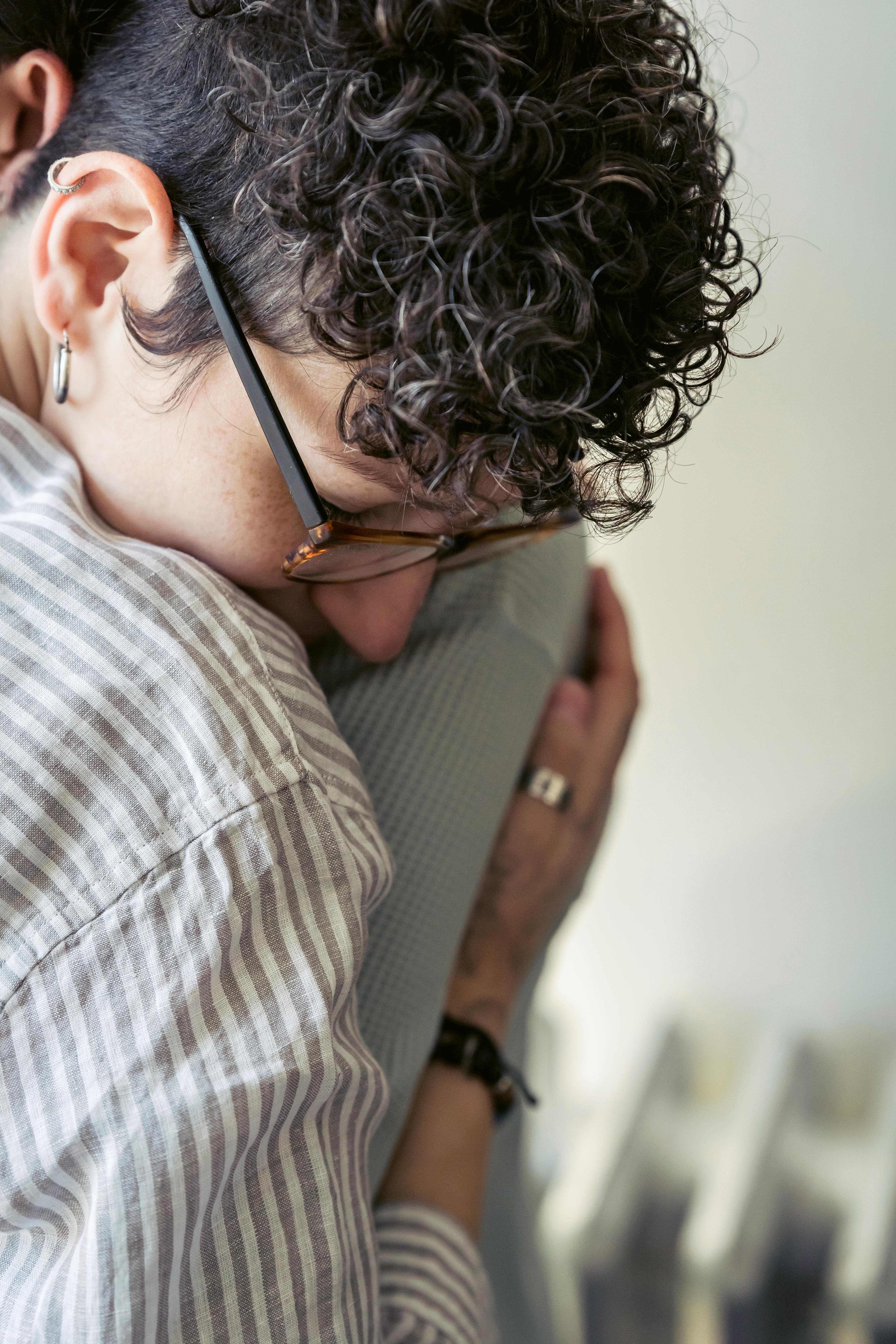 Photo of a Woman with Curly Hair Hugging Another Person · Free Stock Photo