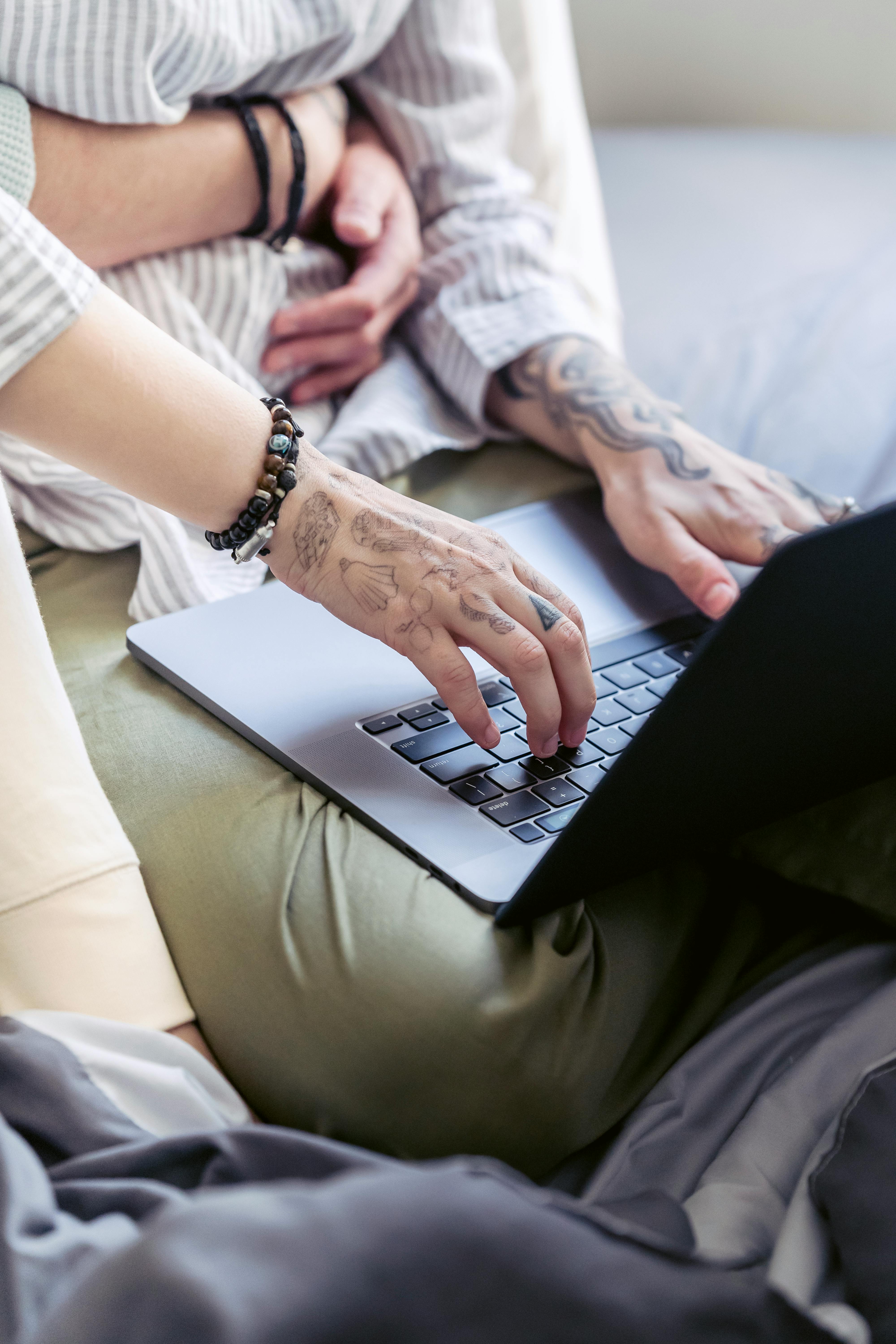 Person With Hand Tattoo Sitting While Using a Laptop Computer · Free ...