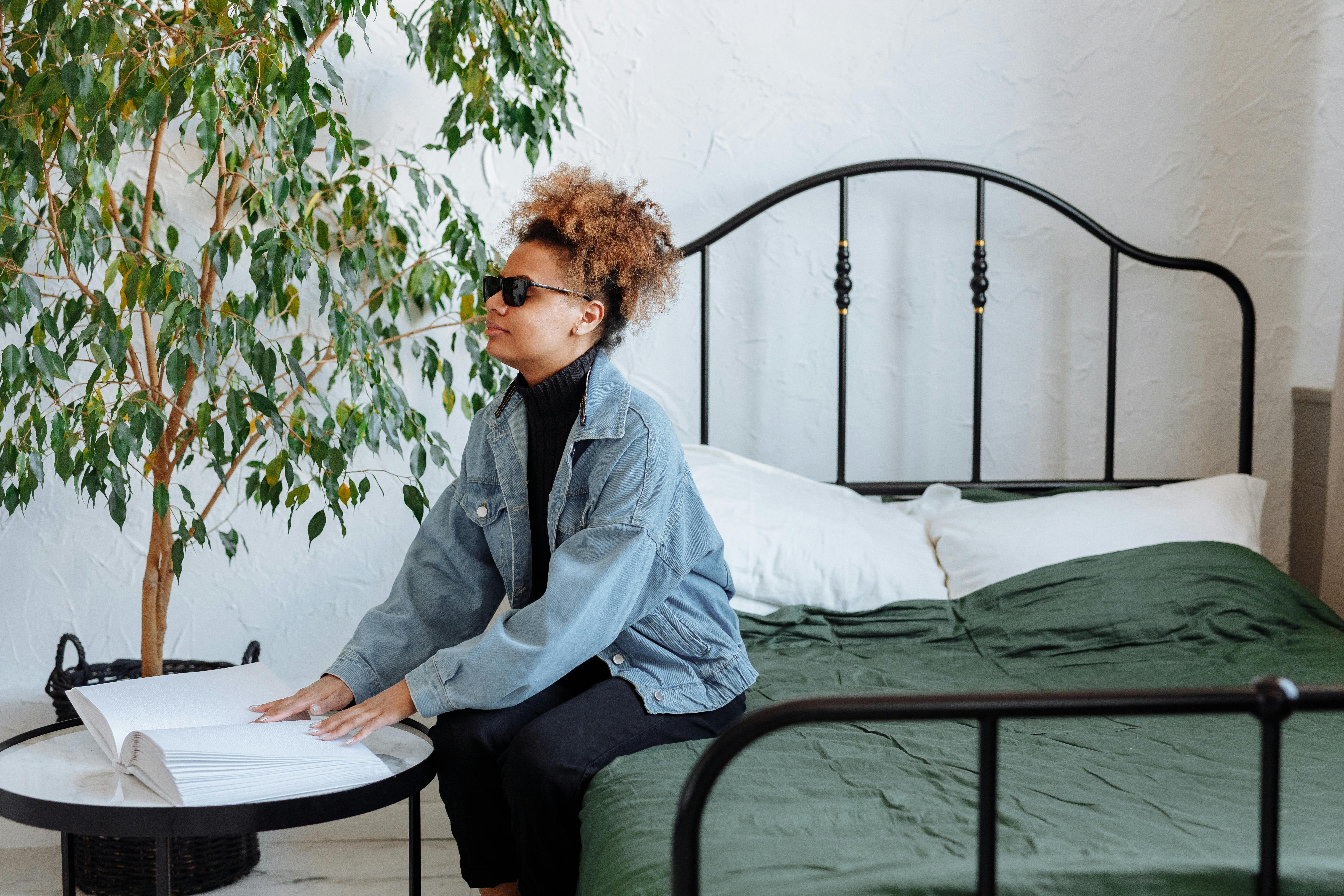 Woman Sitting on a Bed and Reading a Book in Braille Script · Free ...