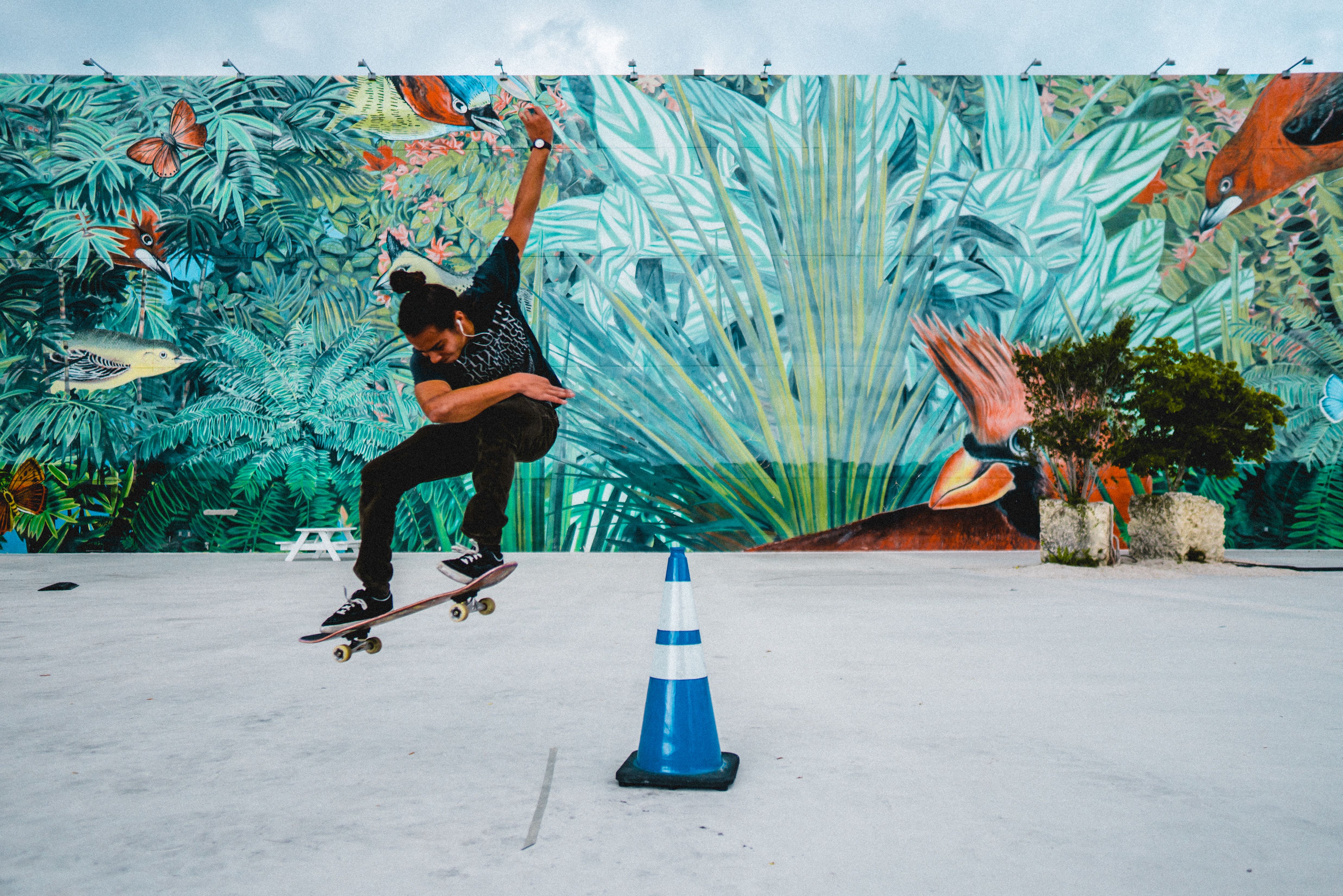 Man Jumping over Cone on Skateboard · Free Stock Photo