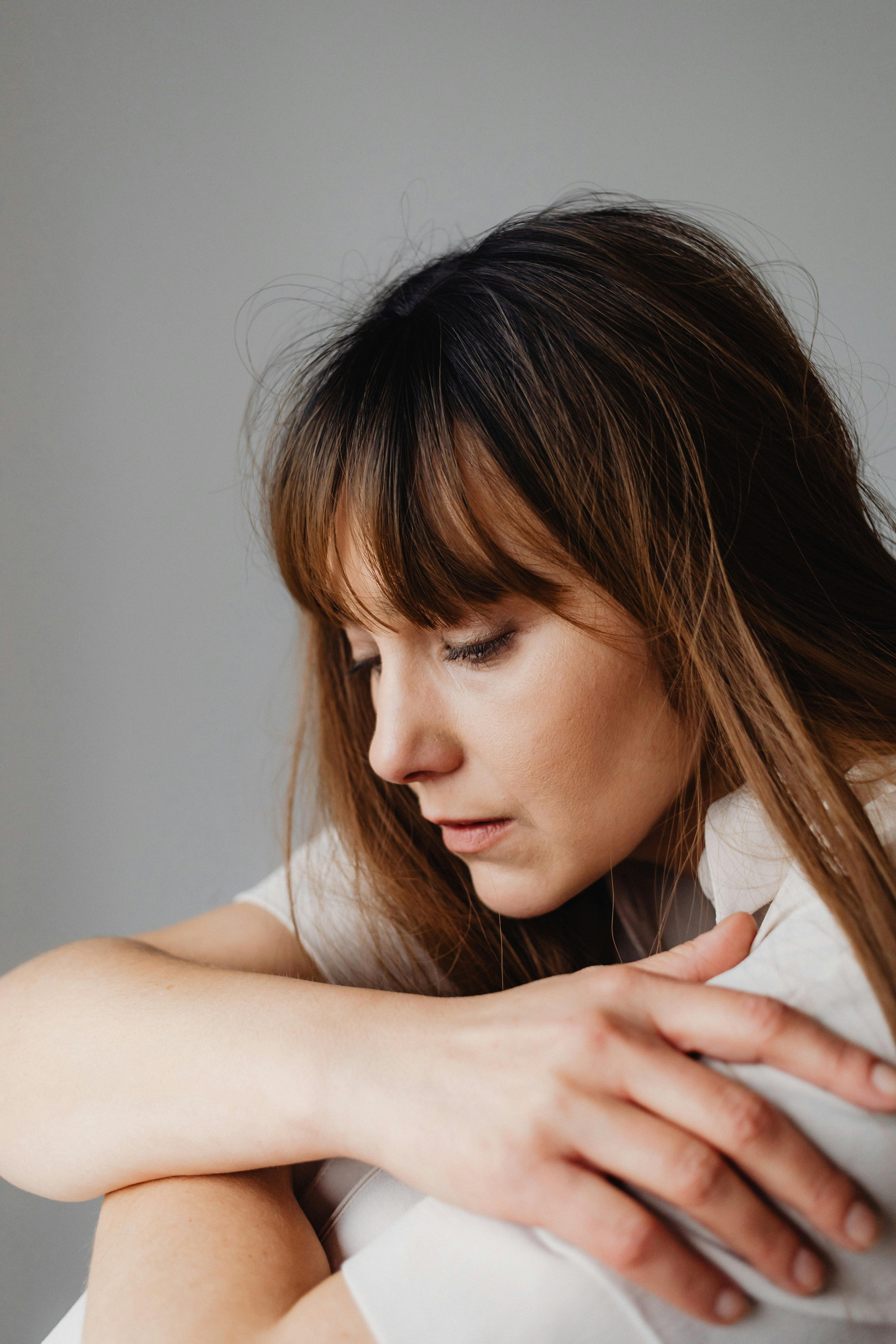 Portrait of a Brunette Woman Hugging Herself Looking Sad · Free Stock Photo