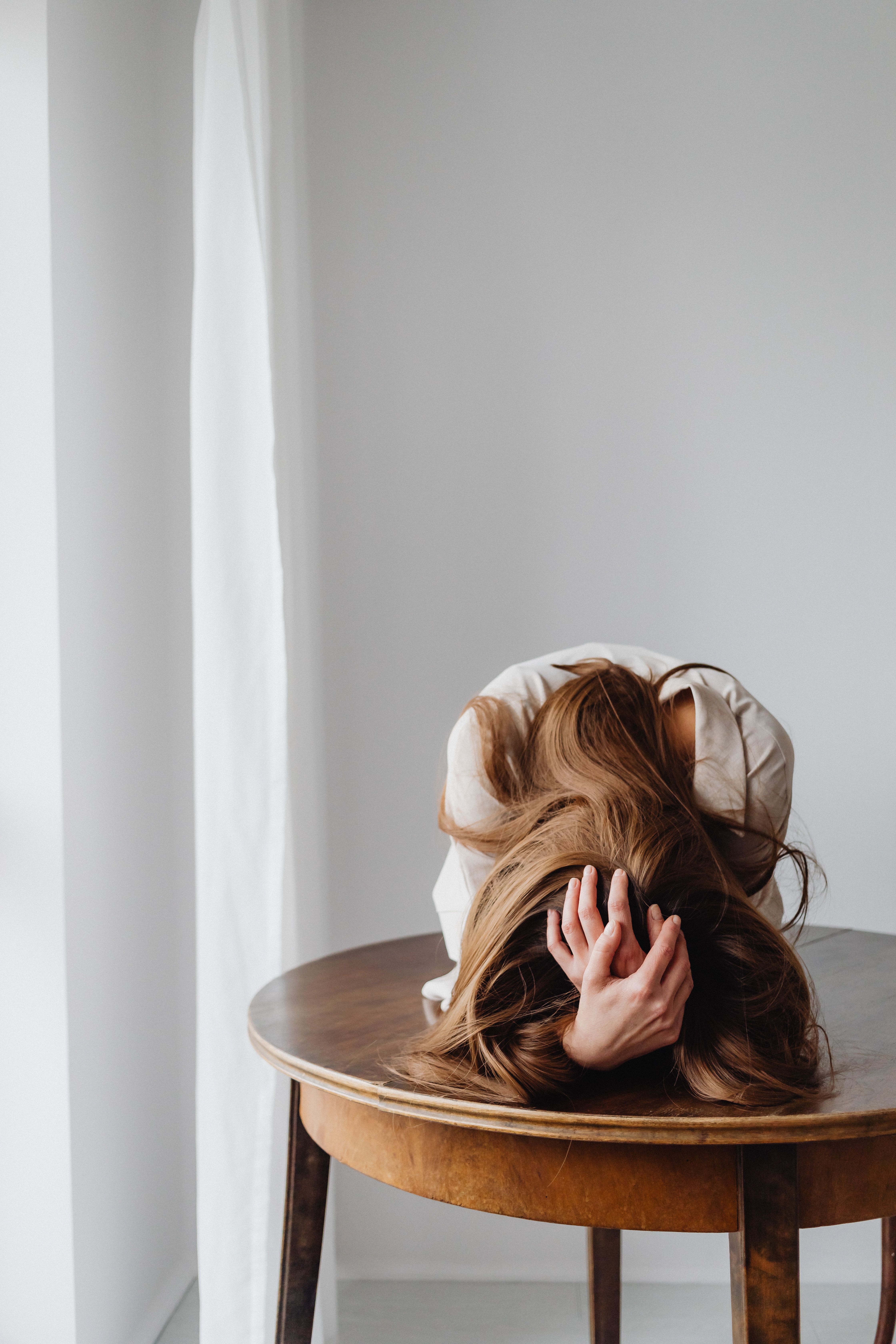 Sad Woman Lying Down on Table · Free Stock Photo