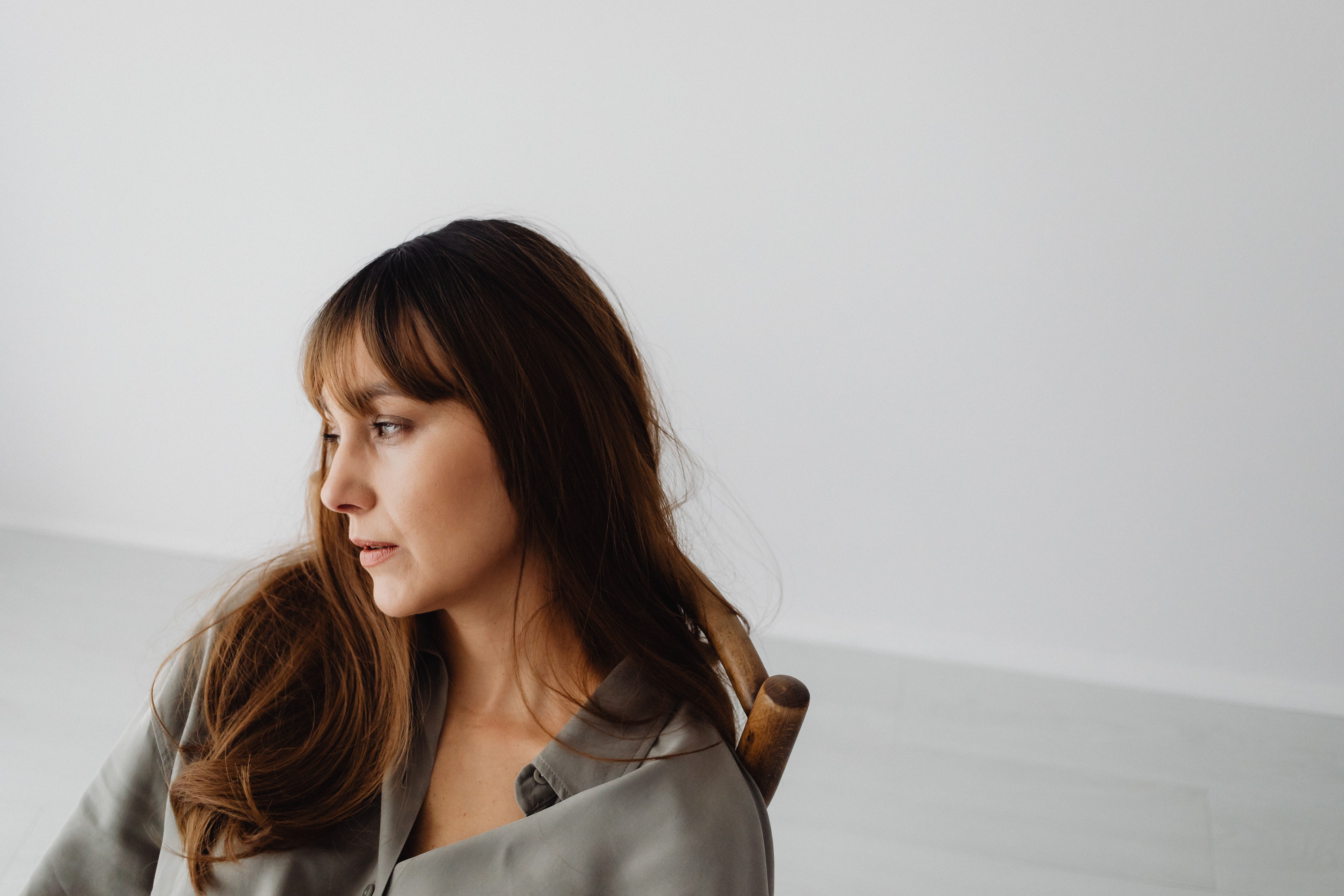 Brunette Woman Sitting on a Chair Looking Tired · Free Stock Photo