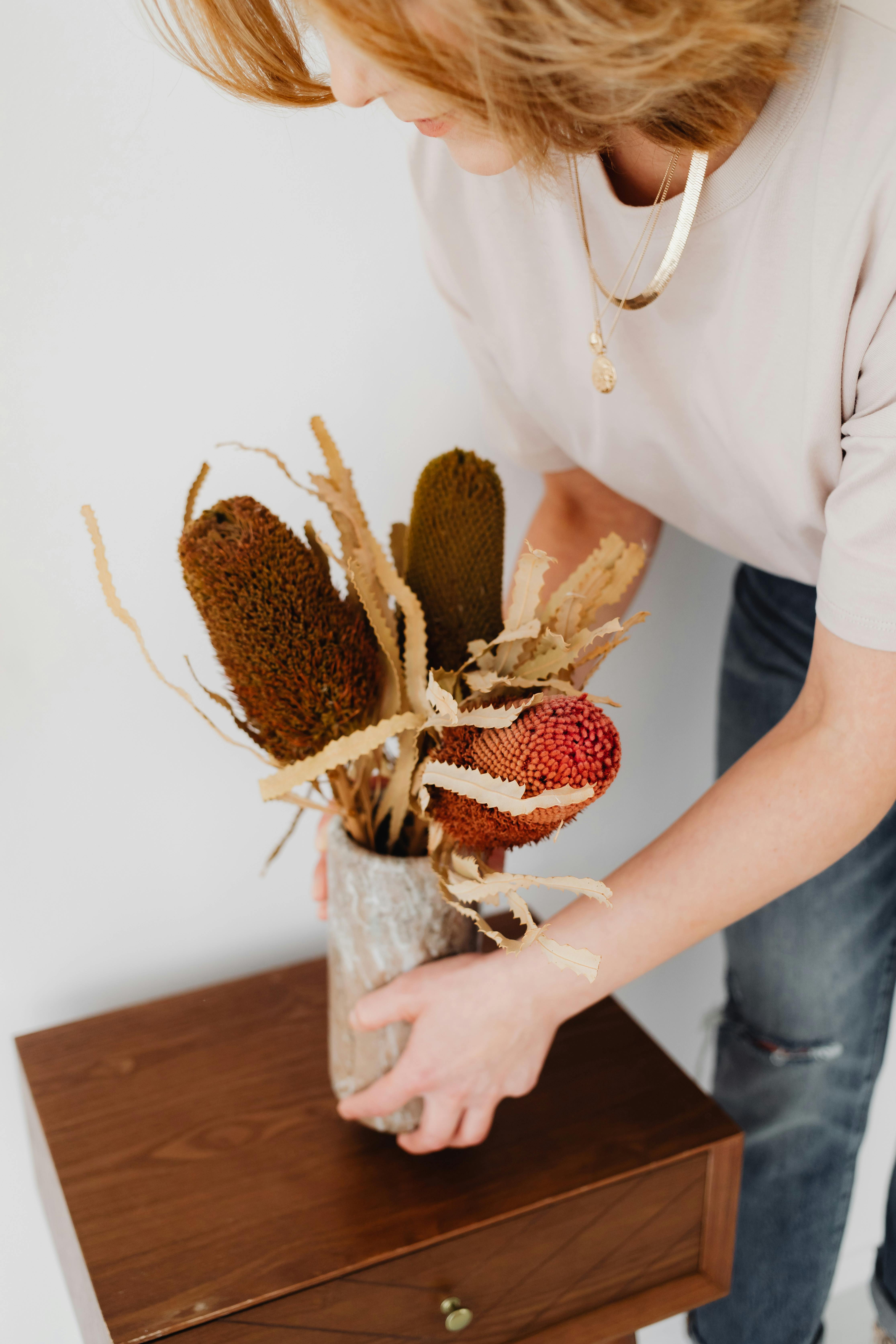 Woman Placing a Vase on the Table · Free Stock Photo