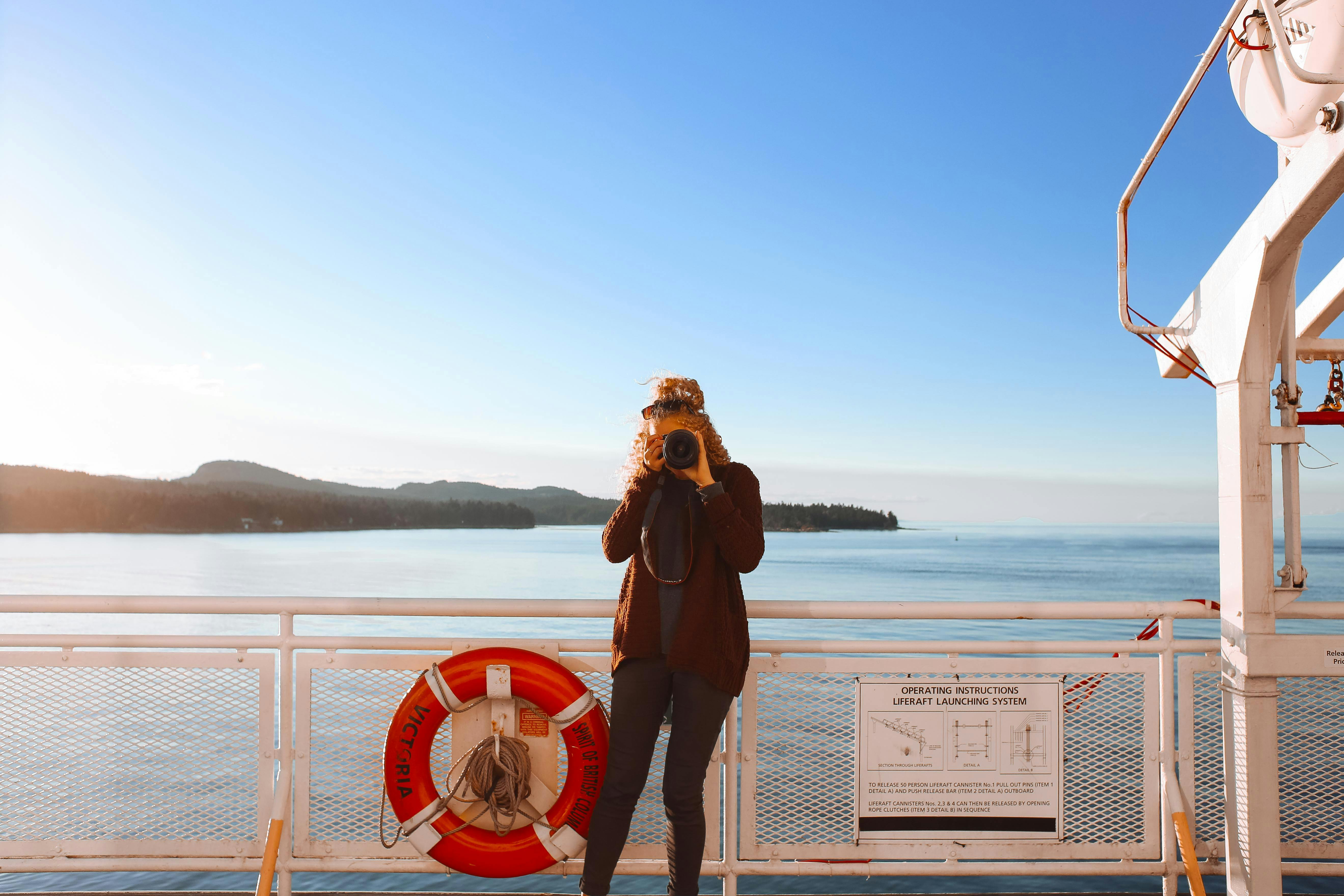 Person in Red Top Standing Near Body of Water · Free Stock Photo