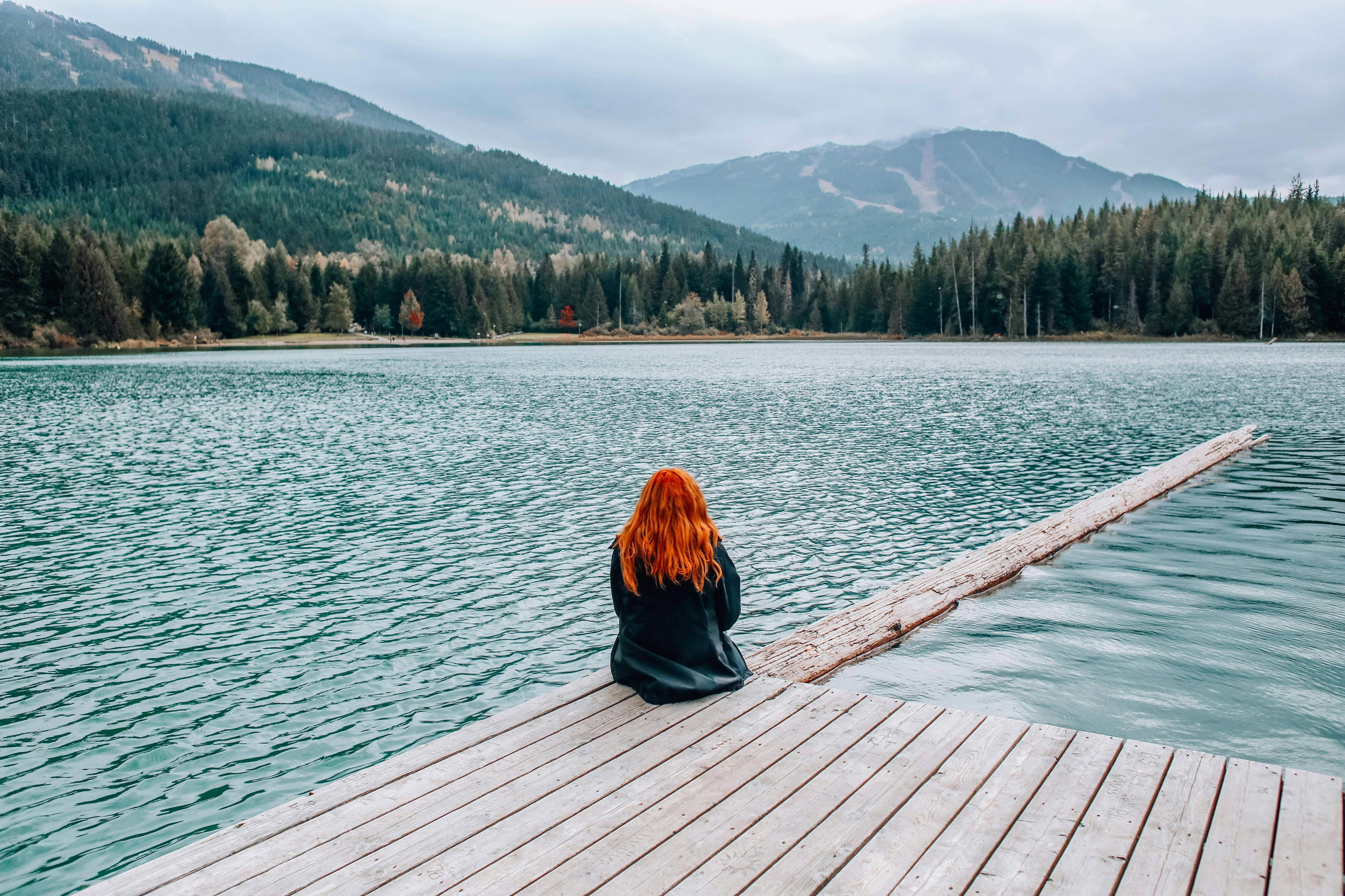 Back View of a Person Sitting on a Dock · Free Stock Photo