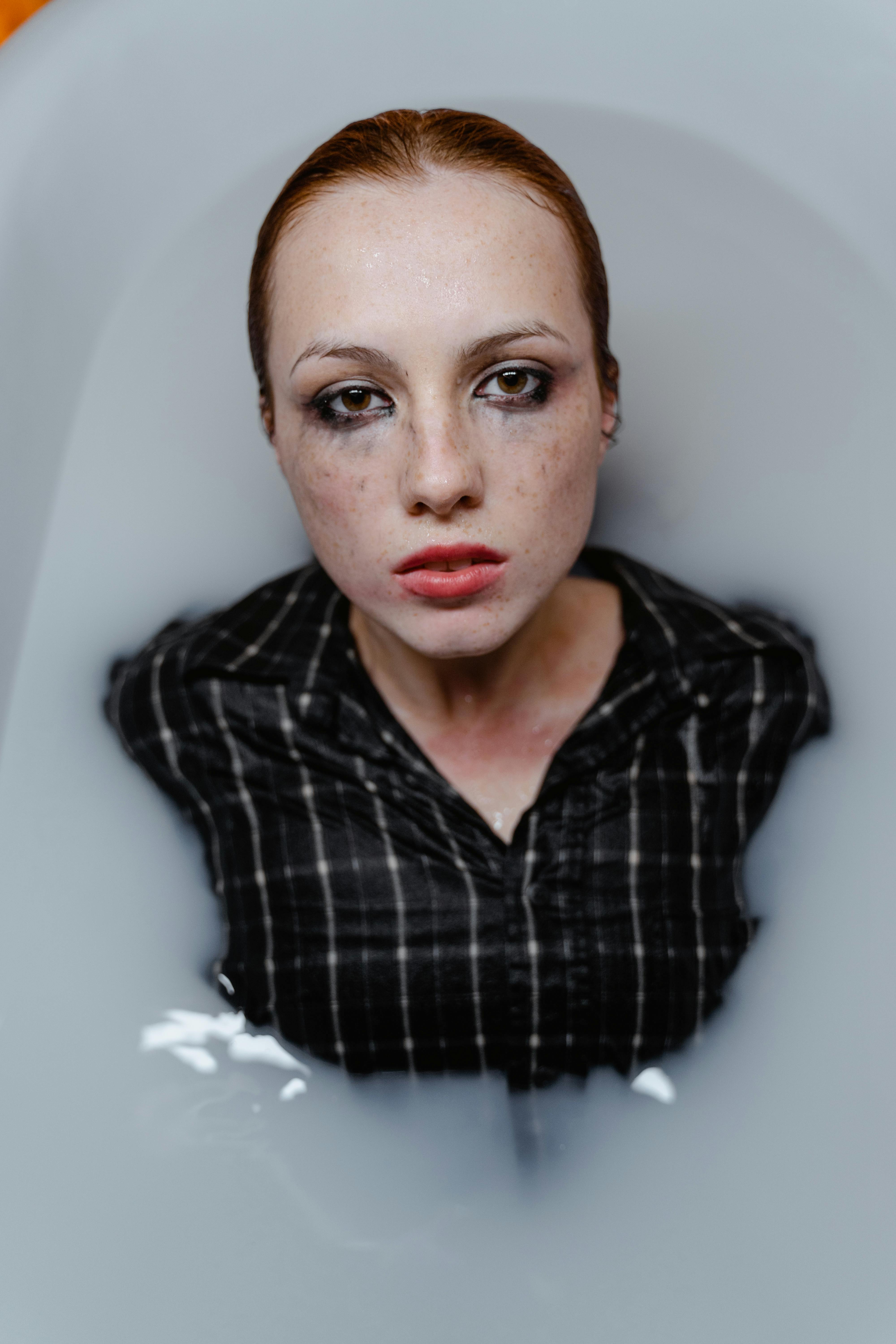 A Fully Clothed Woman Getting Wet in the Bathtub · Free Stock Photo