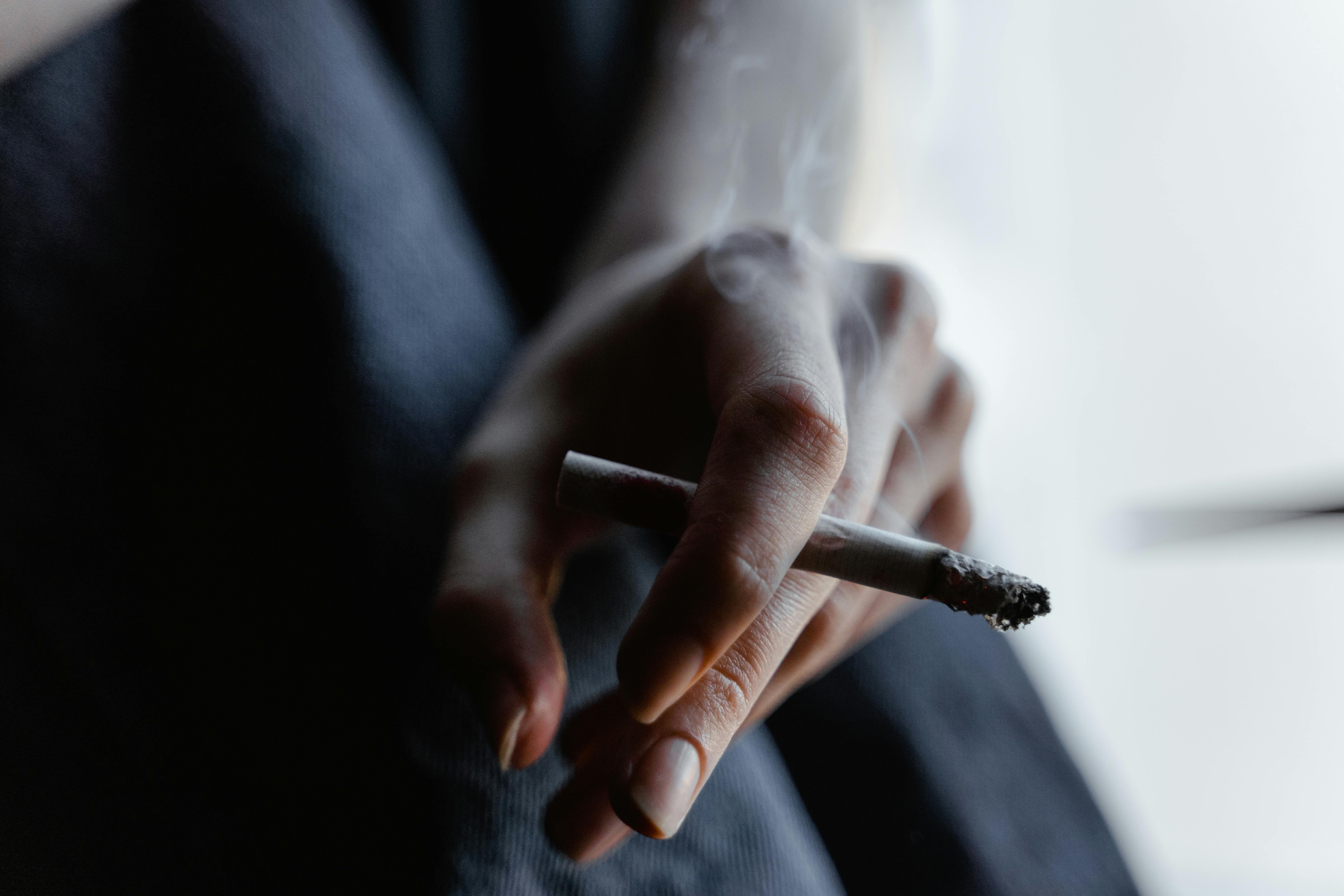 Close-Up Shot of Person Smoking Cigarette · Free Stock Photo