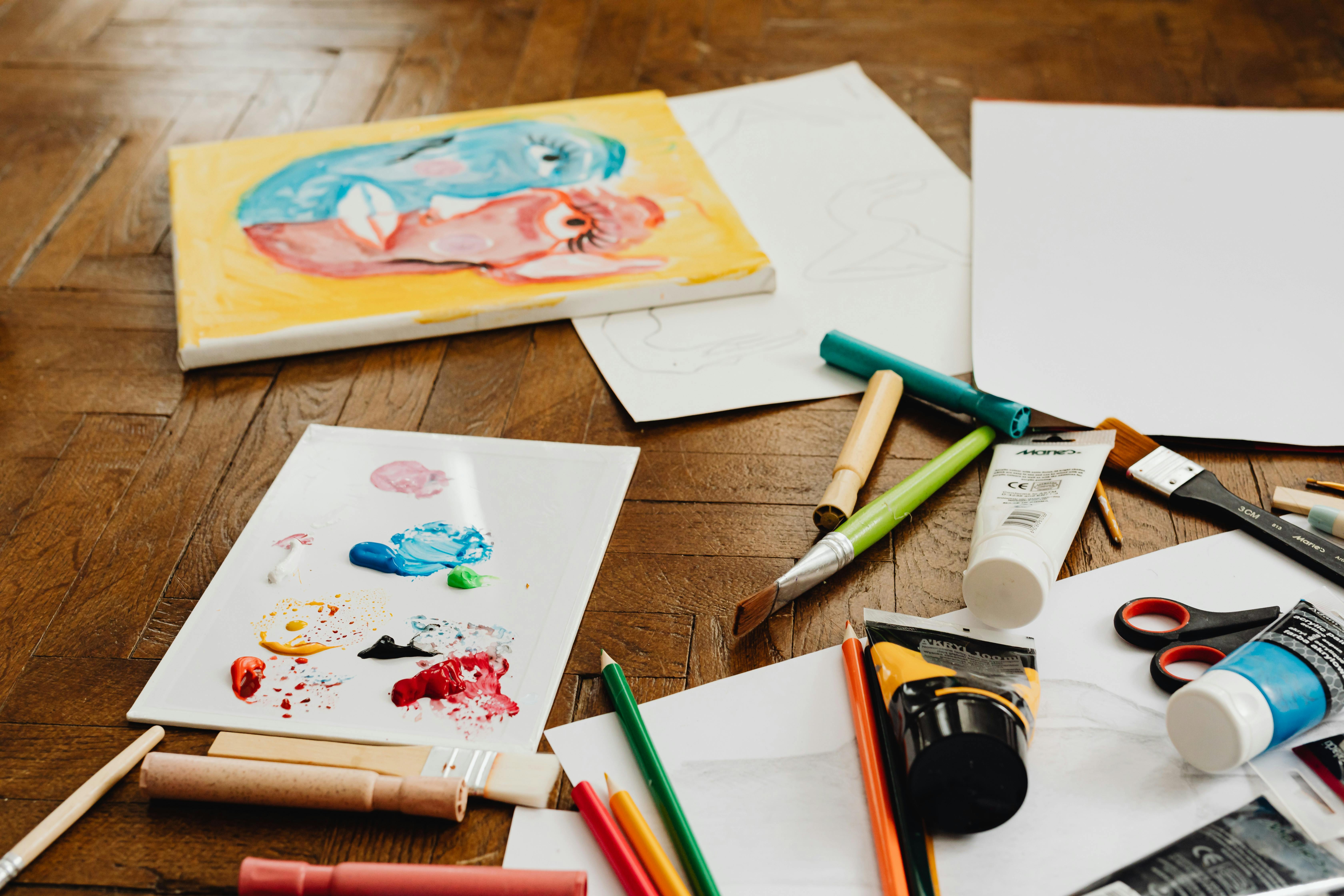 Scattered Art Materials on a Wooden Surface · Free Stock Photo