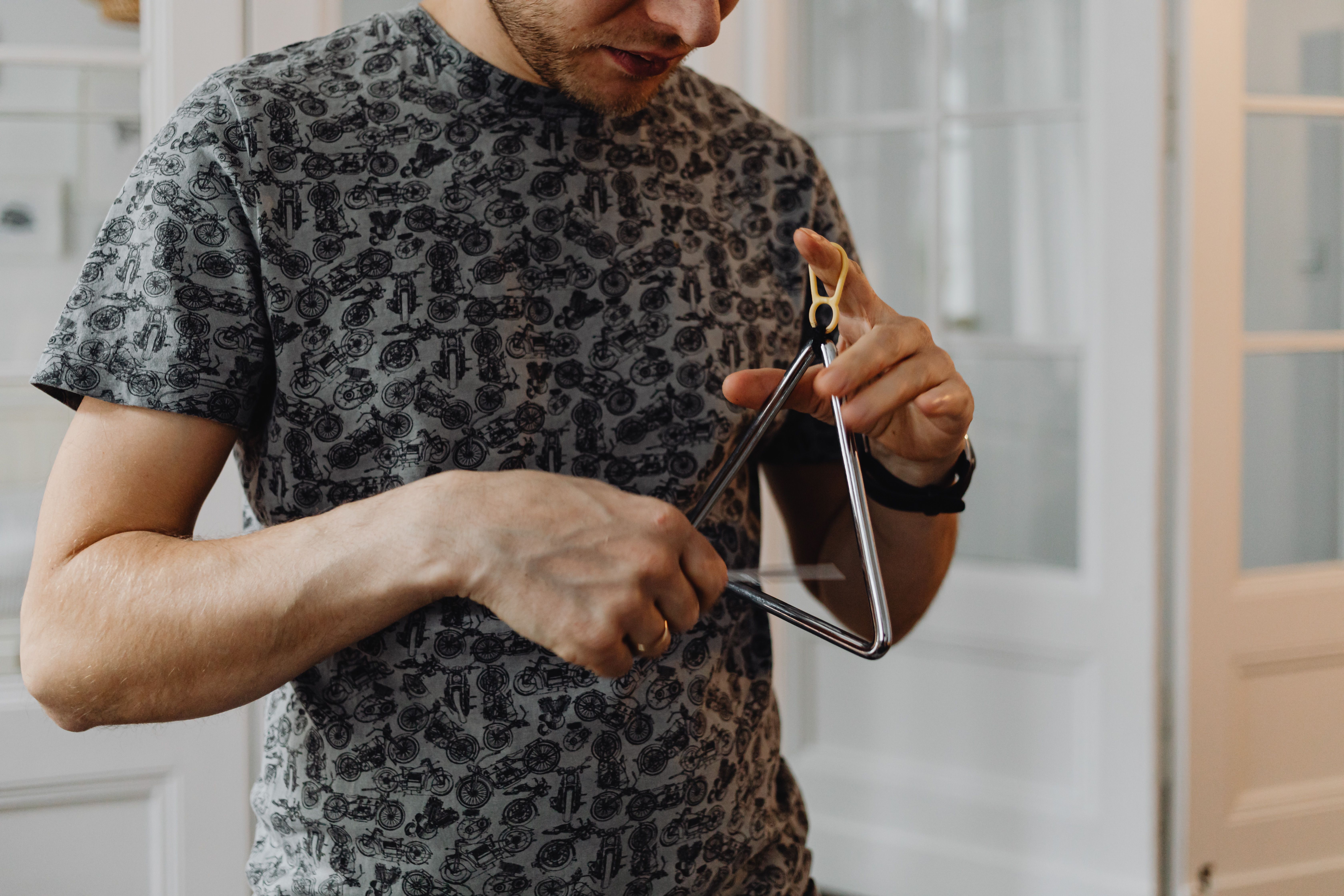 Close-Up Shot of a Person Playing a Triangle Instrument · Free Stock Photo