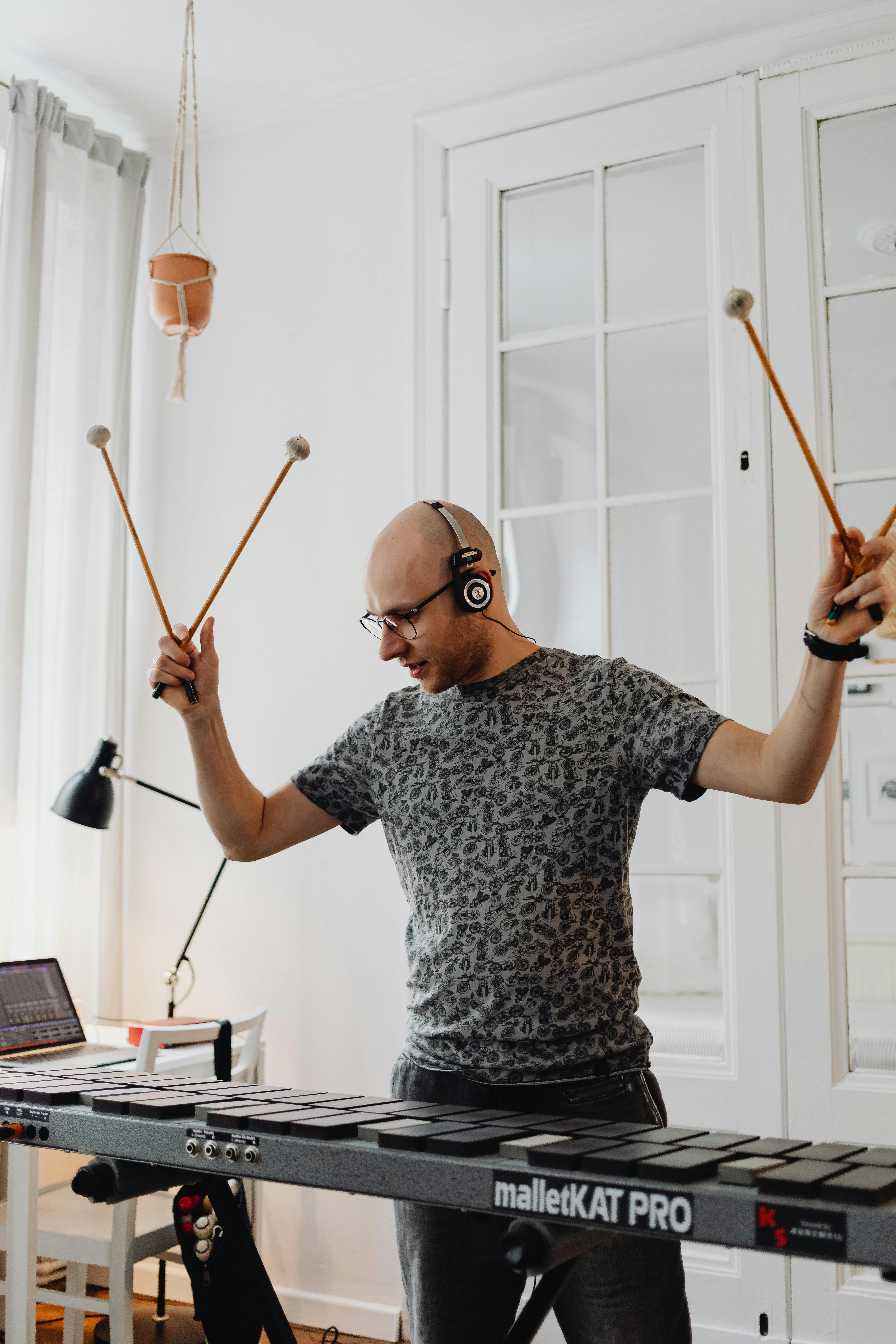 A Man Raising His Hands while Holding Mallets · Free Stock Photo