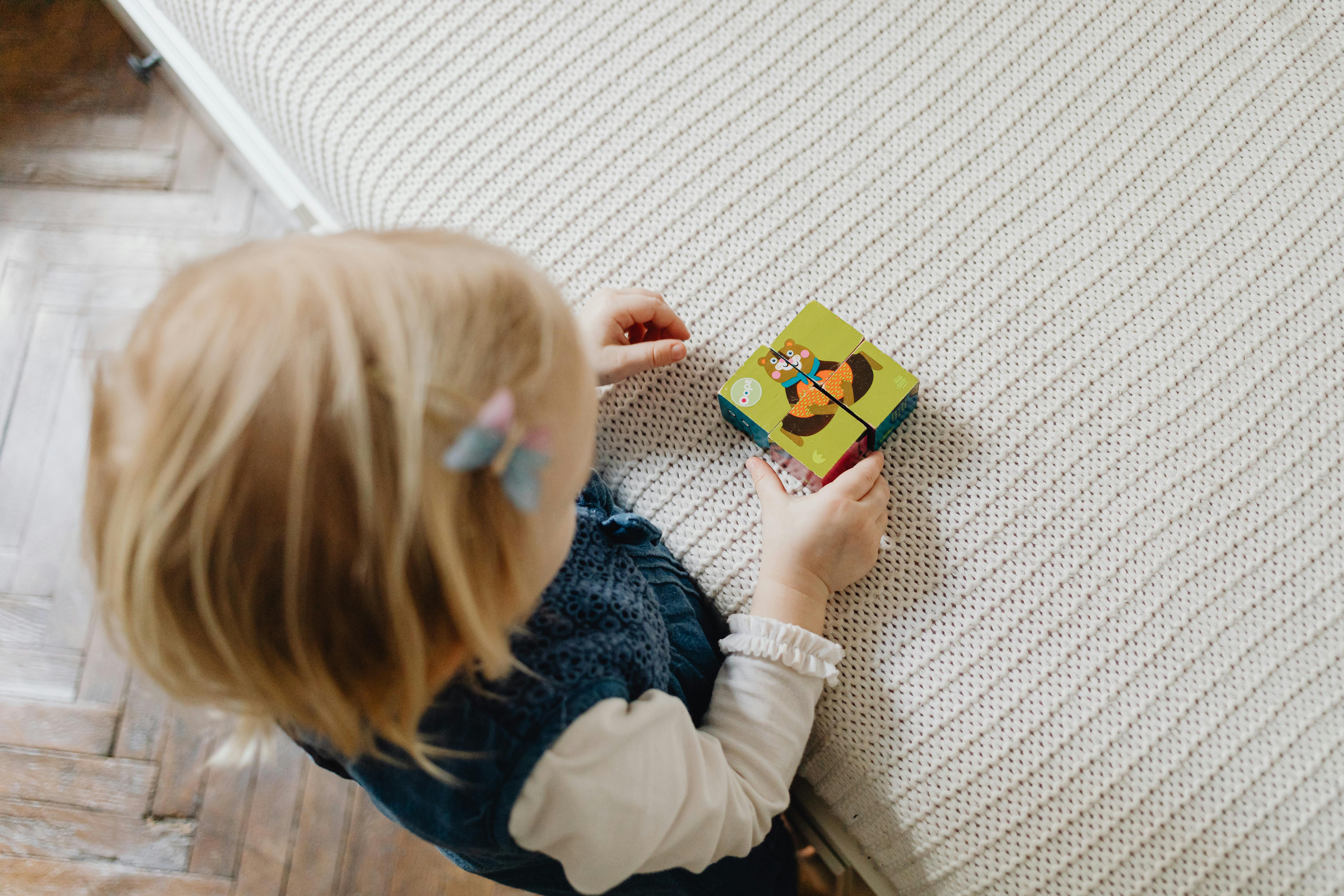 A Child Playing with a Block Puzzle · Free Stock Photo