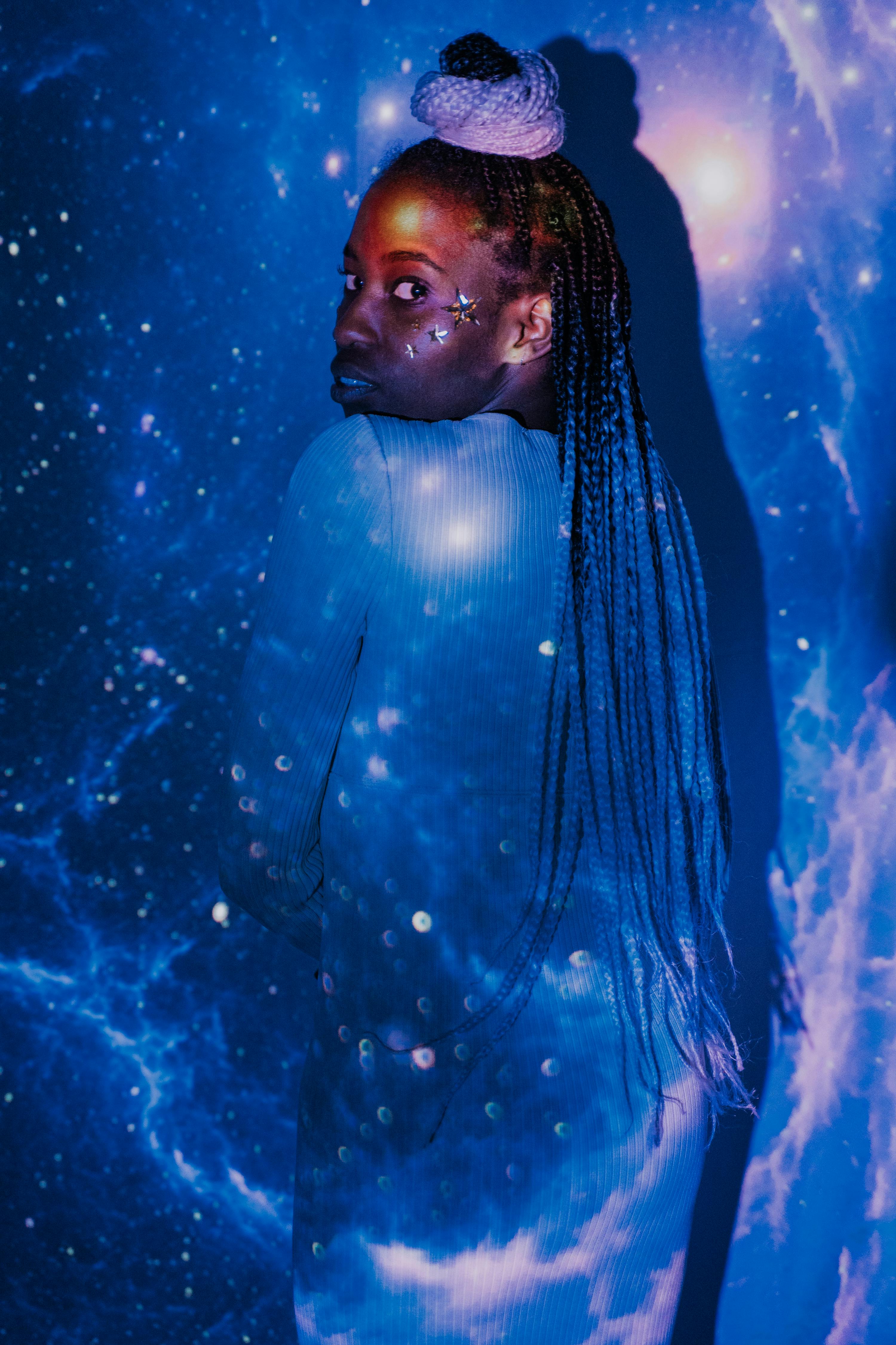 A Woman Standing in Front of a Projector Screen · Free Stock Photo