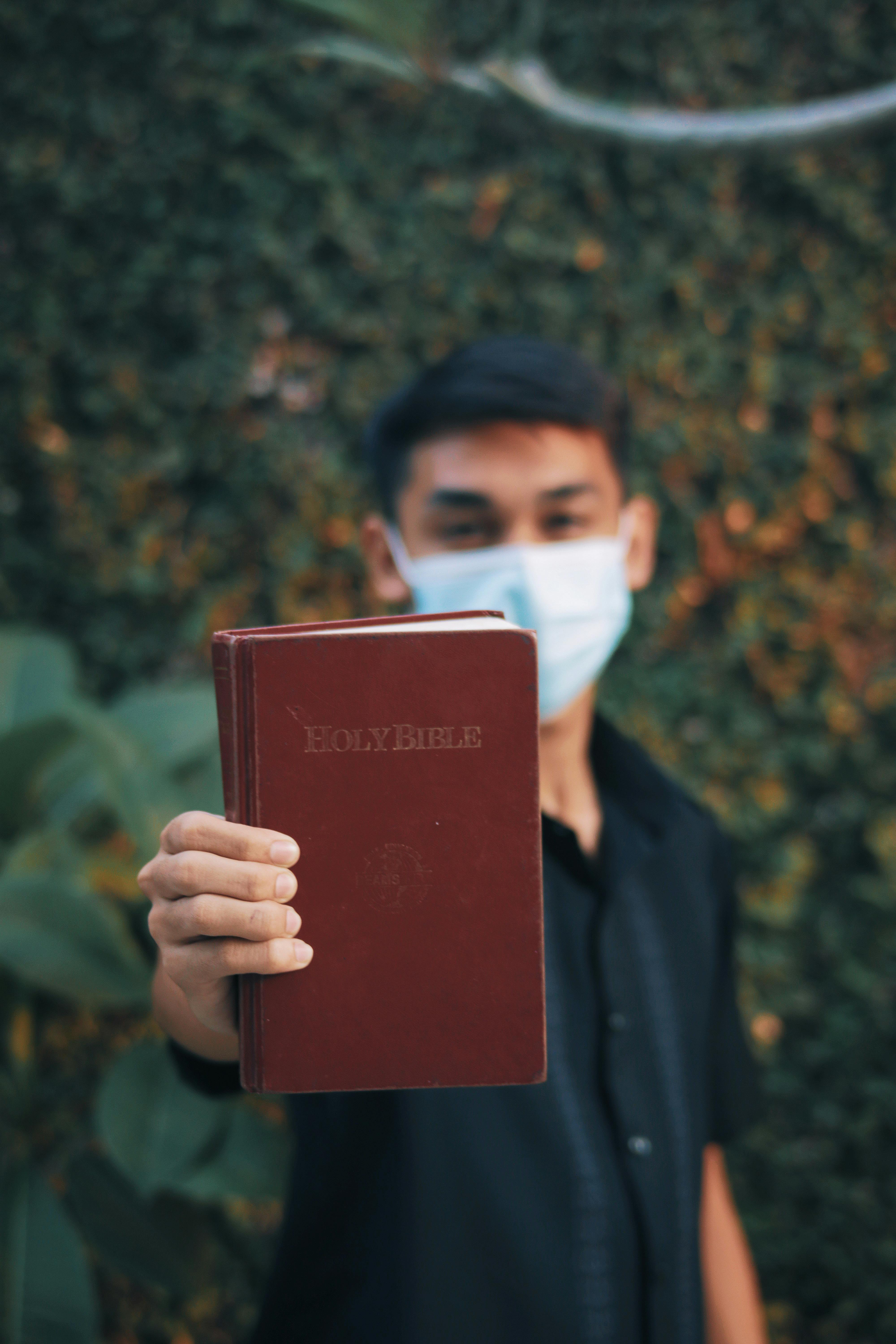 Man Holding a Holy Bible · Free Stock Photo