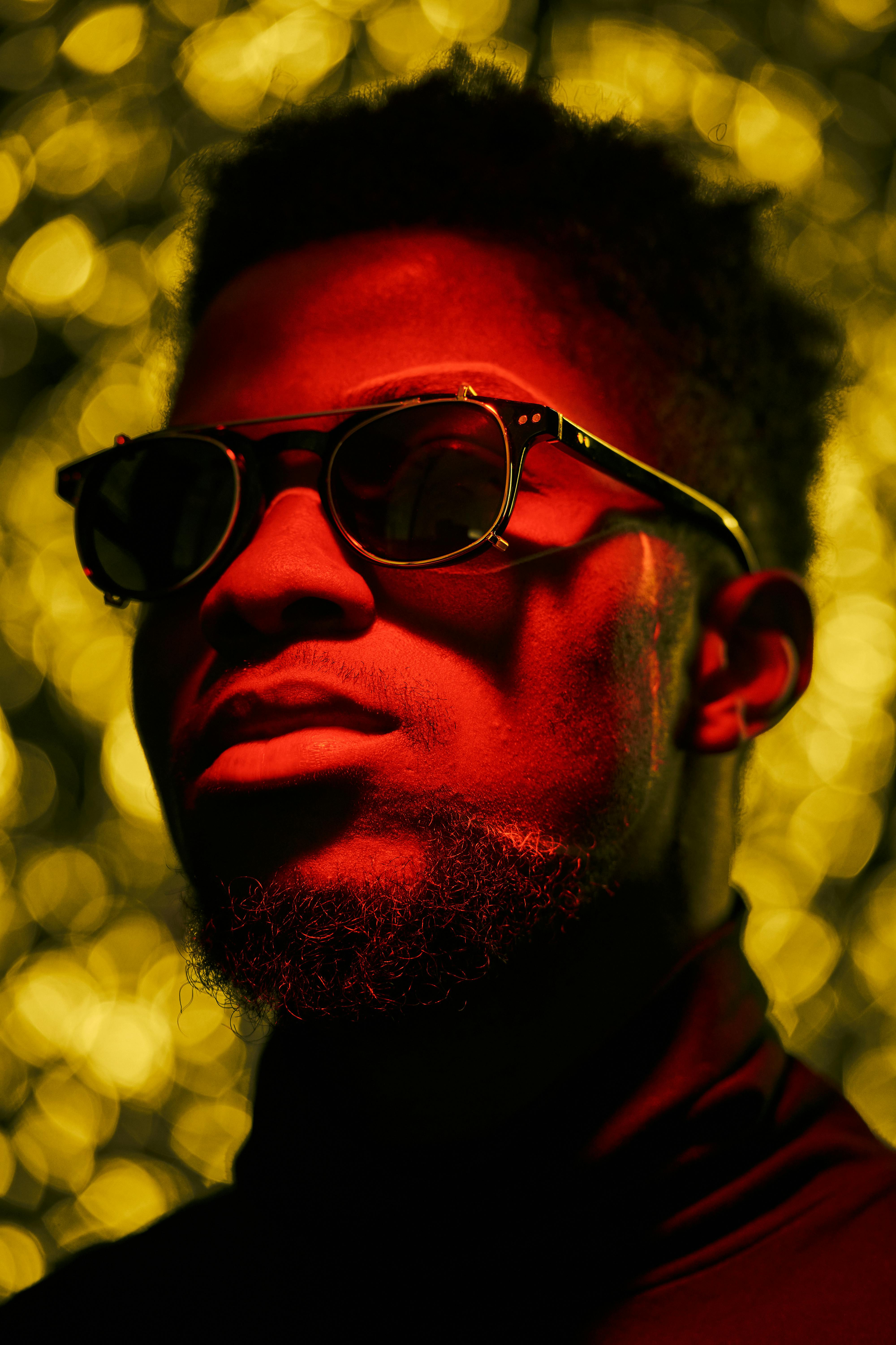 A Man Wearing Shades with a Red Light · Free Stock Photo