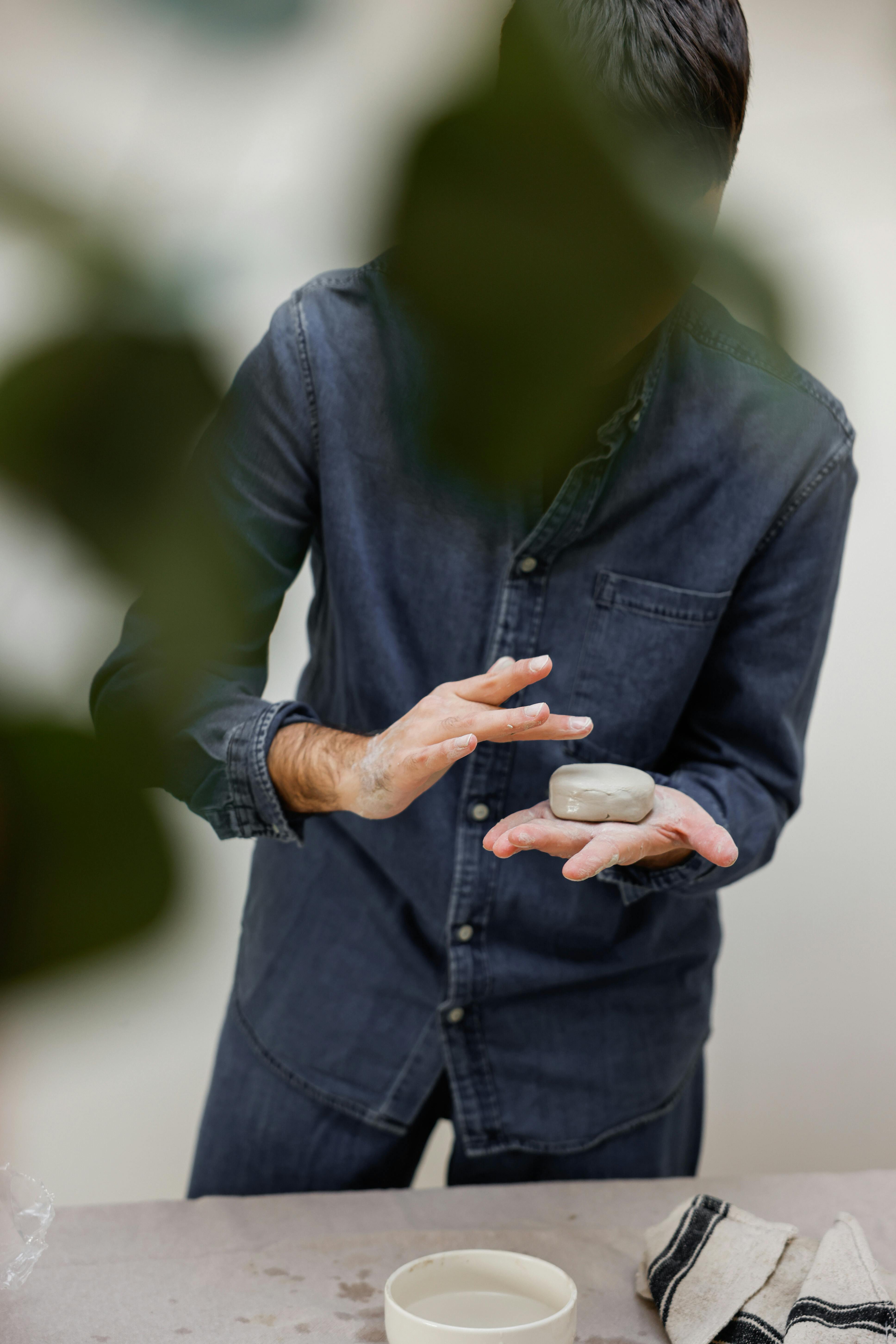 Man Shaping Clay on his Hand · Free Stock Photo