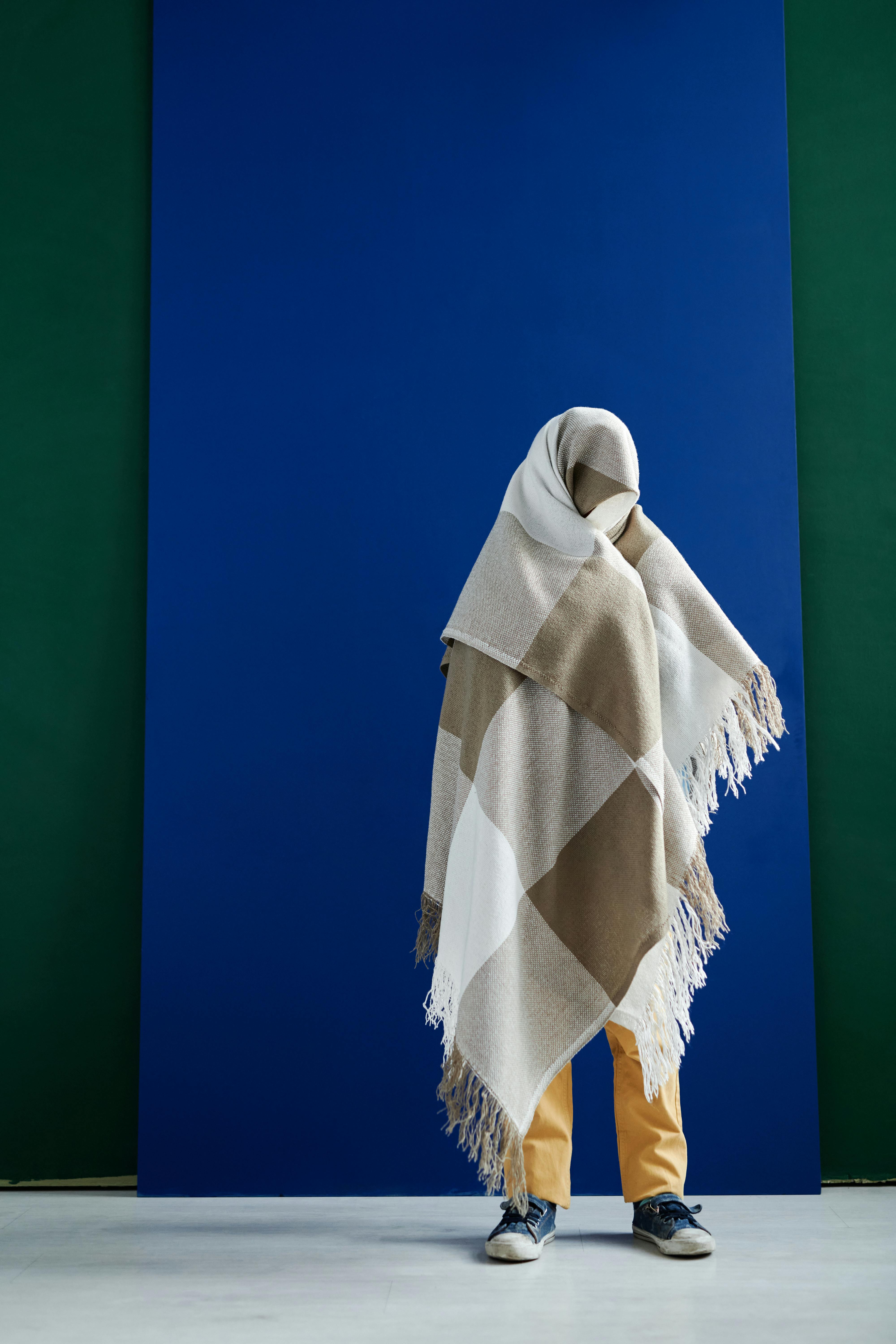 Person Covered With Scarf on Blue Wall · Free Stock Photo