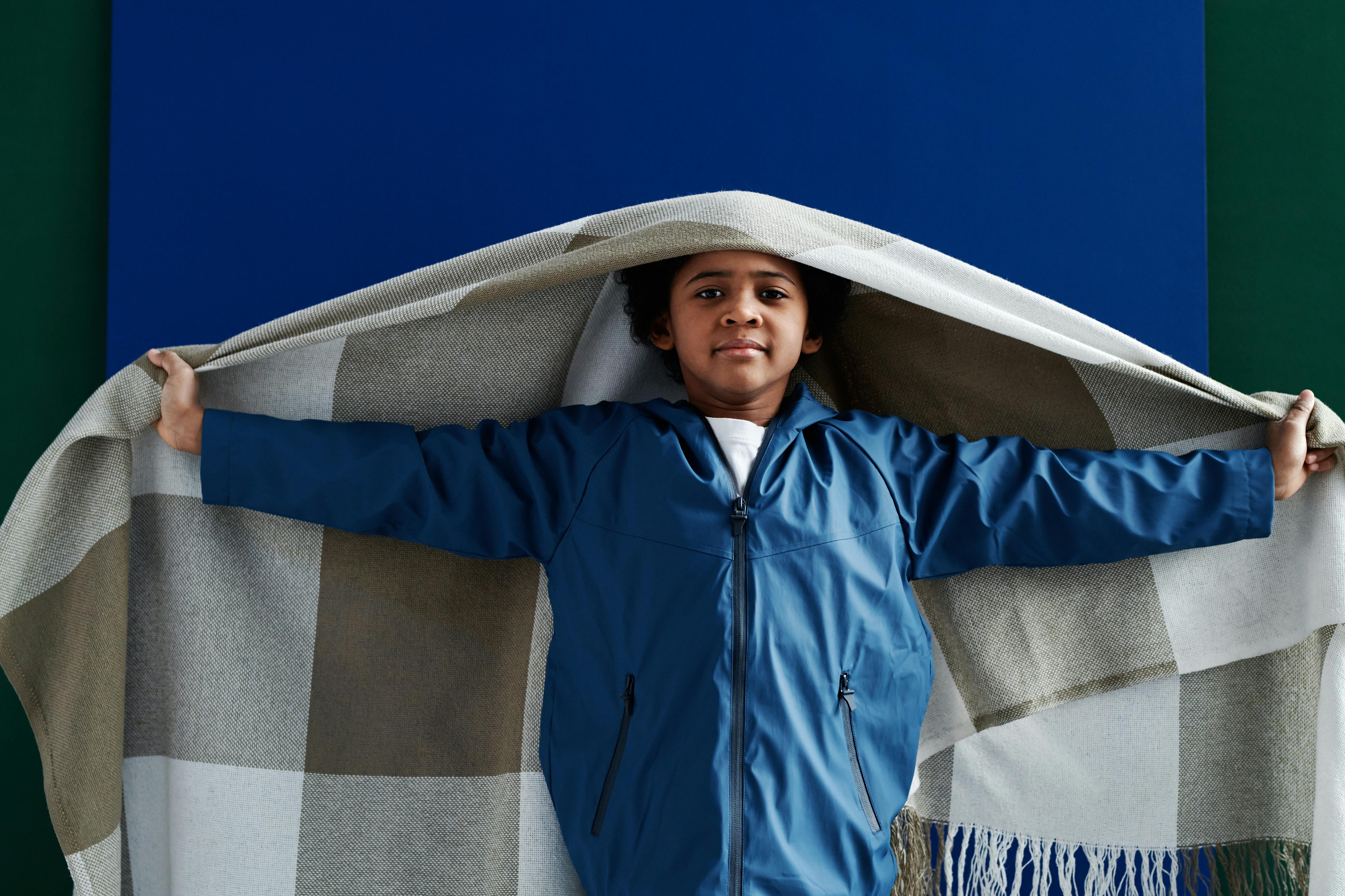 Boy in Blue Jacket Holding a Blanket · Free Stock Photo