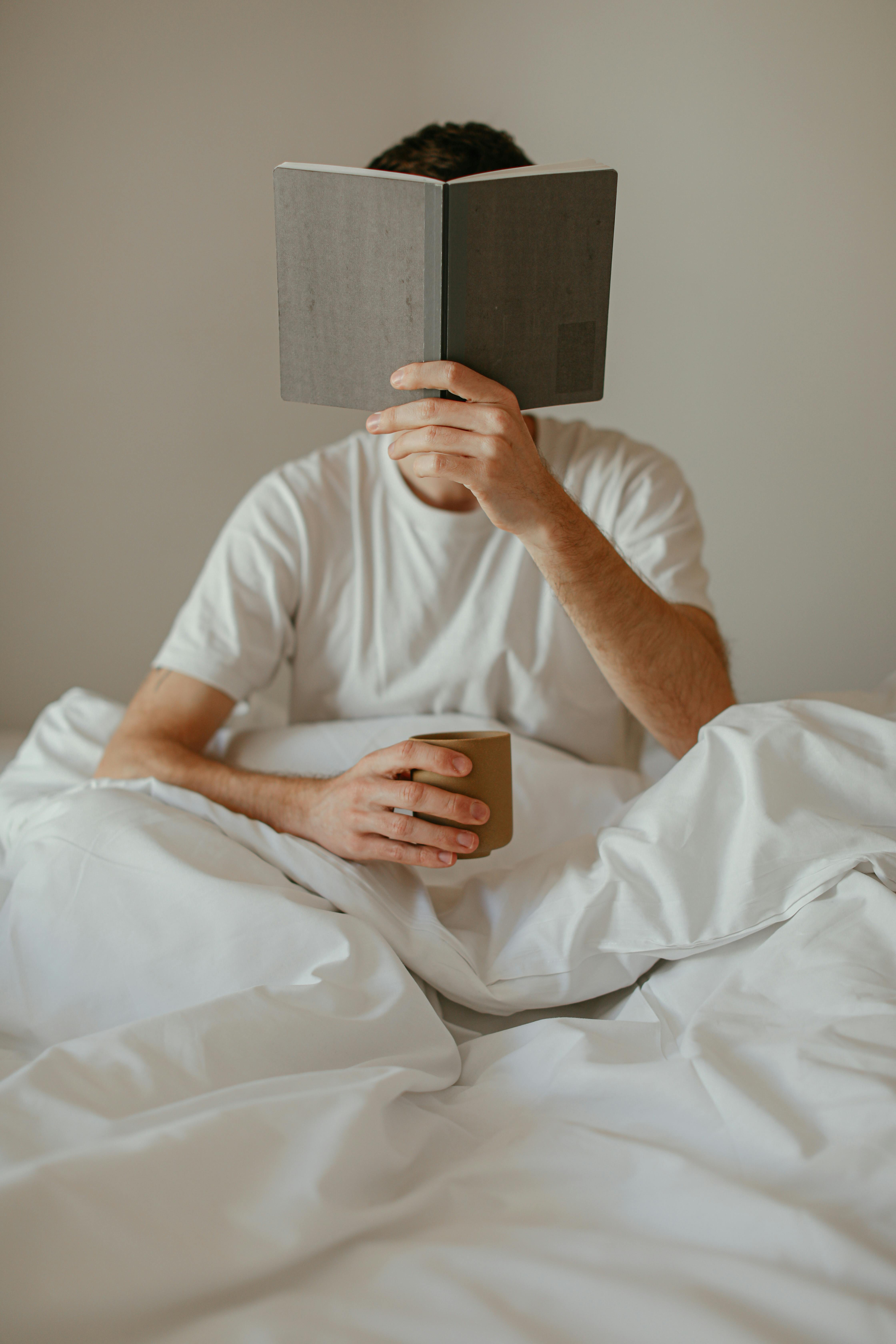 Man in White Shirt Reading a Book · Free Stock Photo