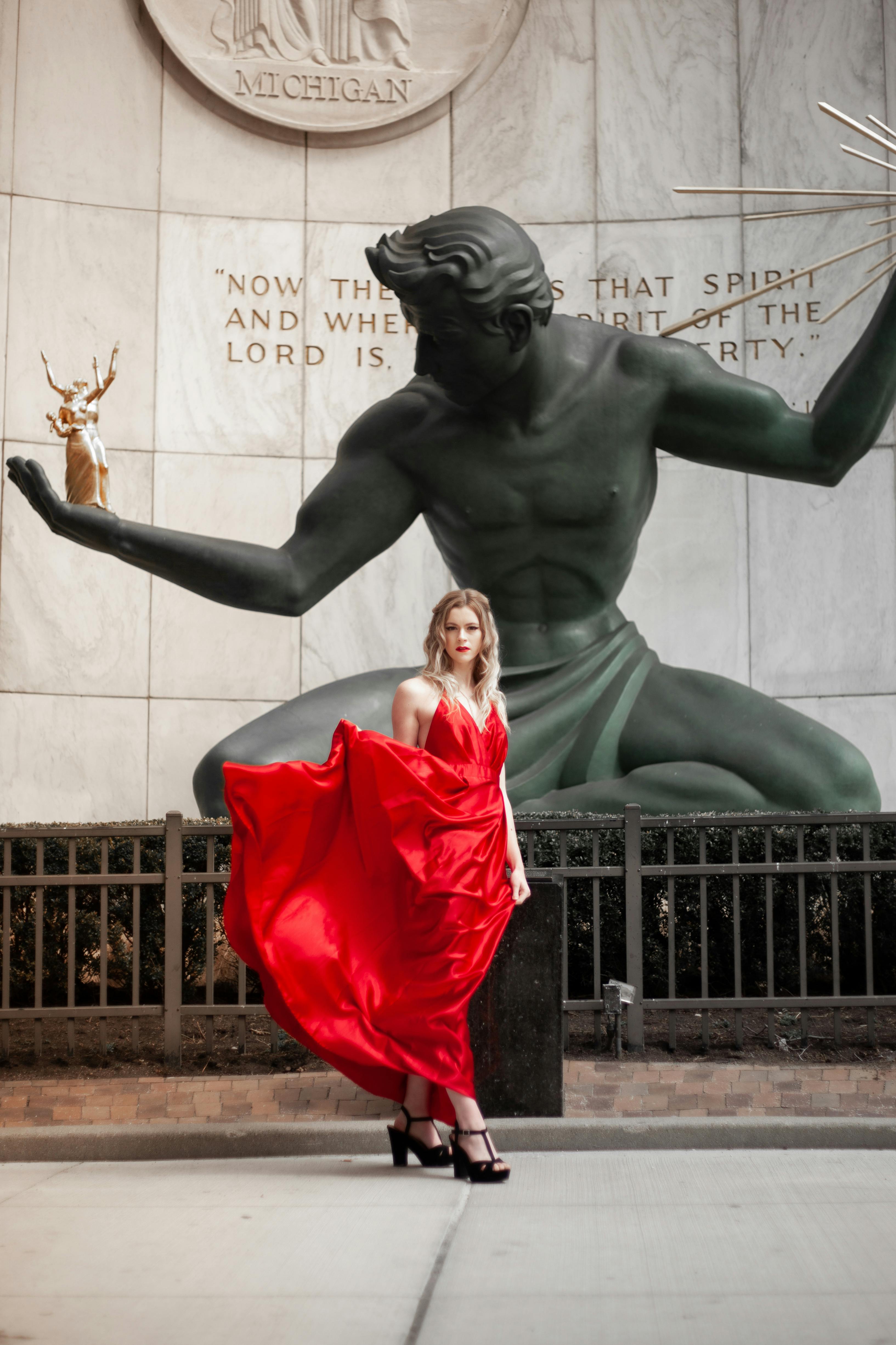 Woman in Red Dress Standing Near a Statue · Free Stock Photo