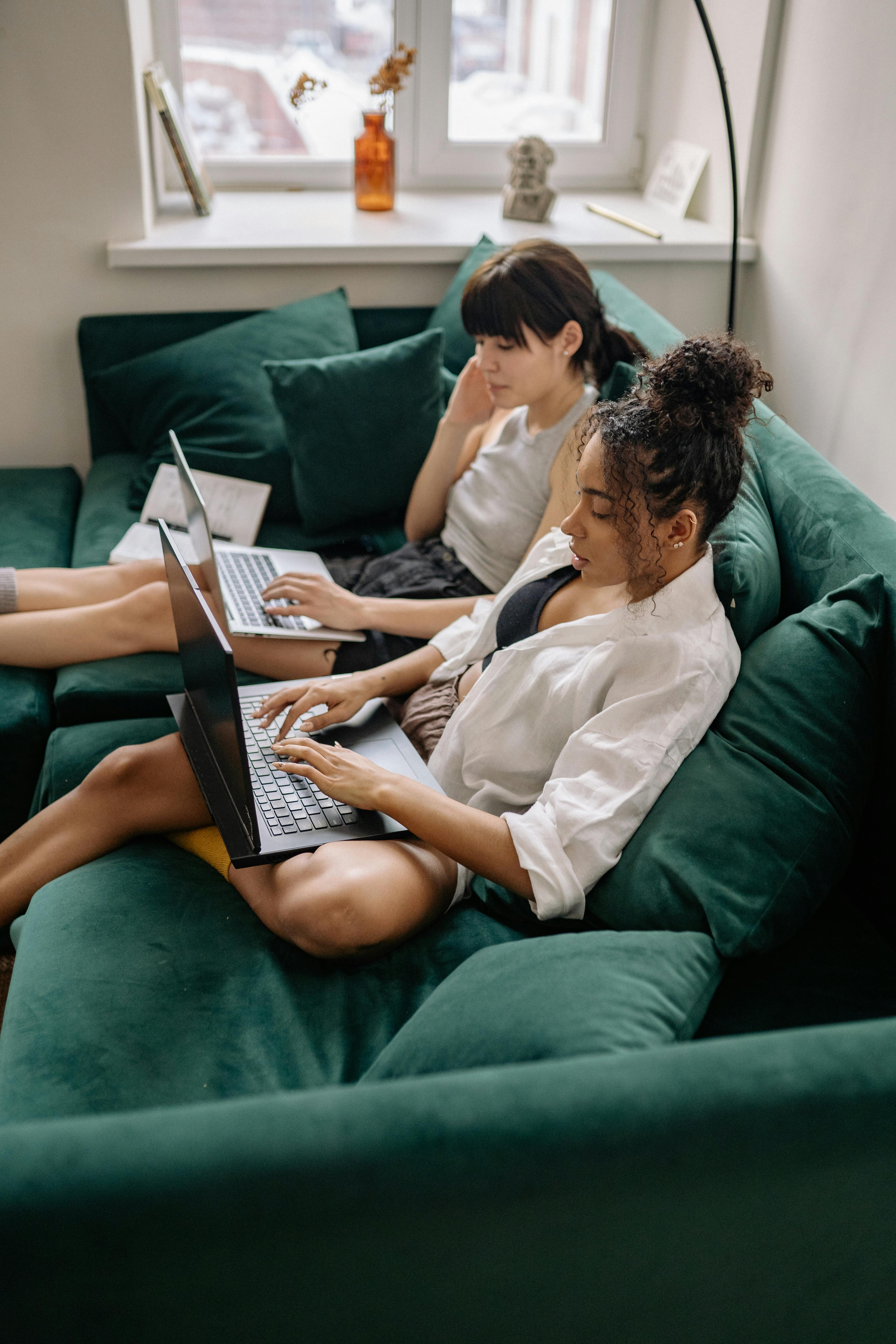 Young Women Using Laptop while Sitting on the Couch · Free Stock Photo