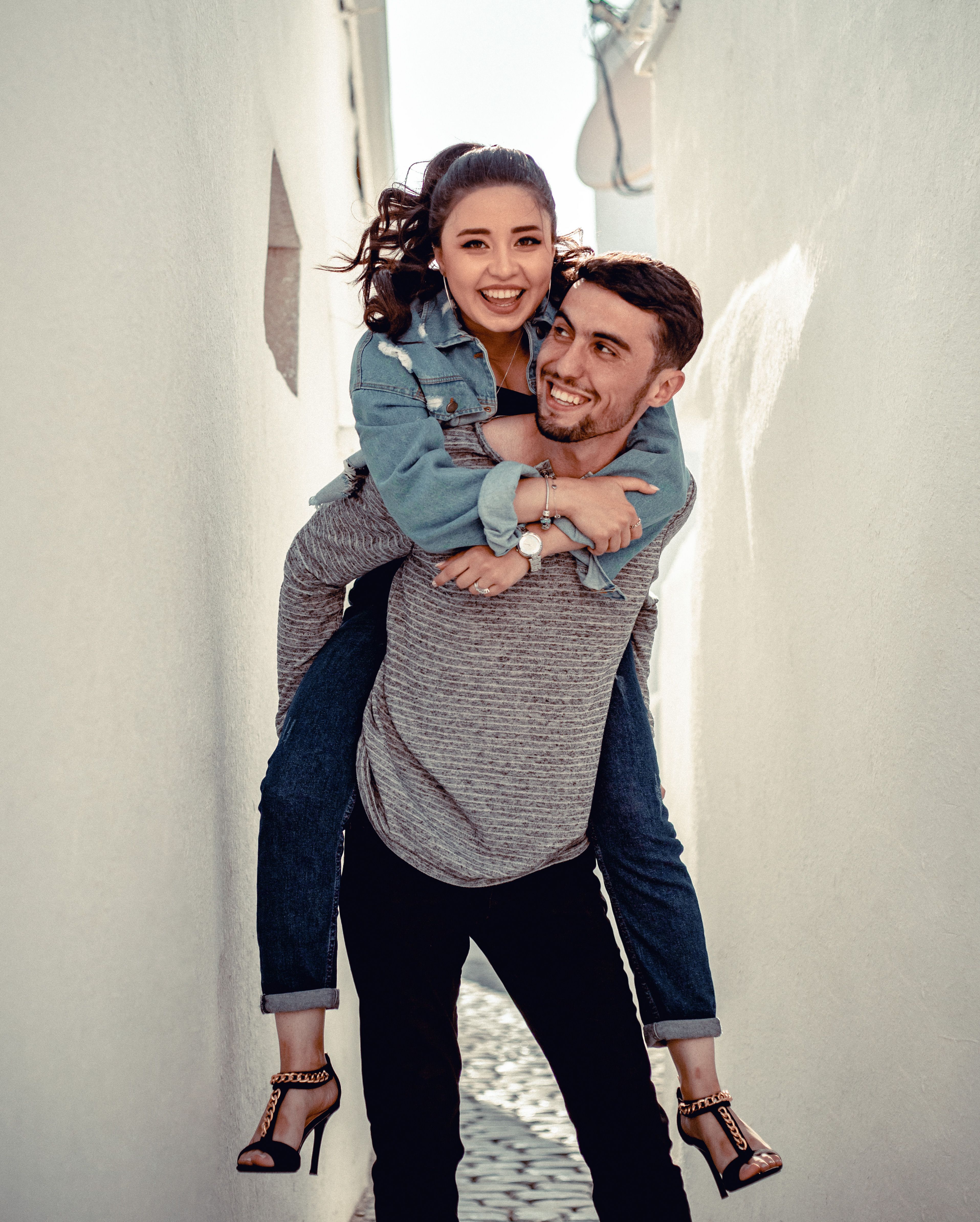 Happy diverse couple cuddling on street · Free Stock Photo