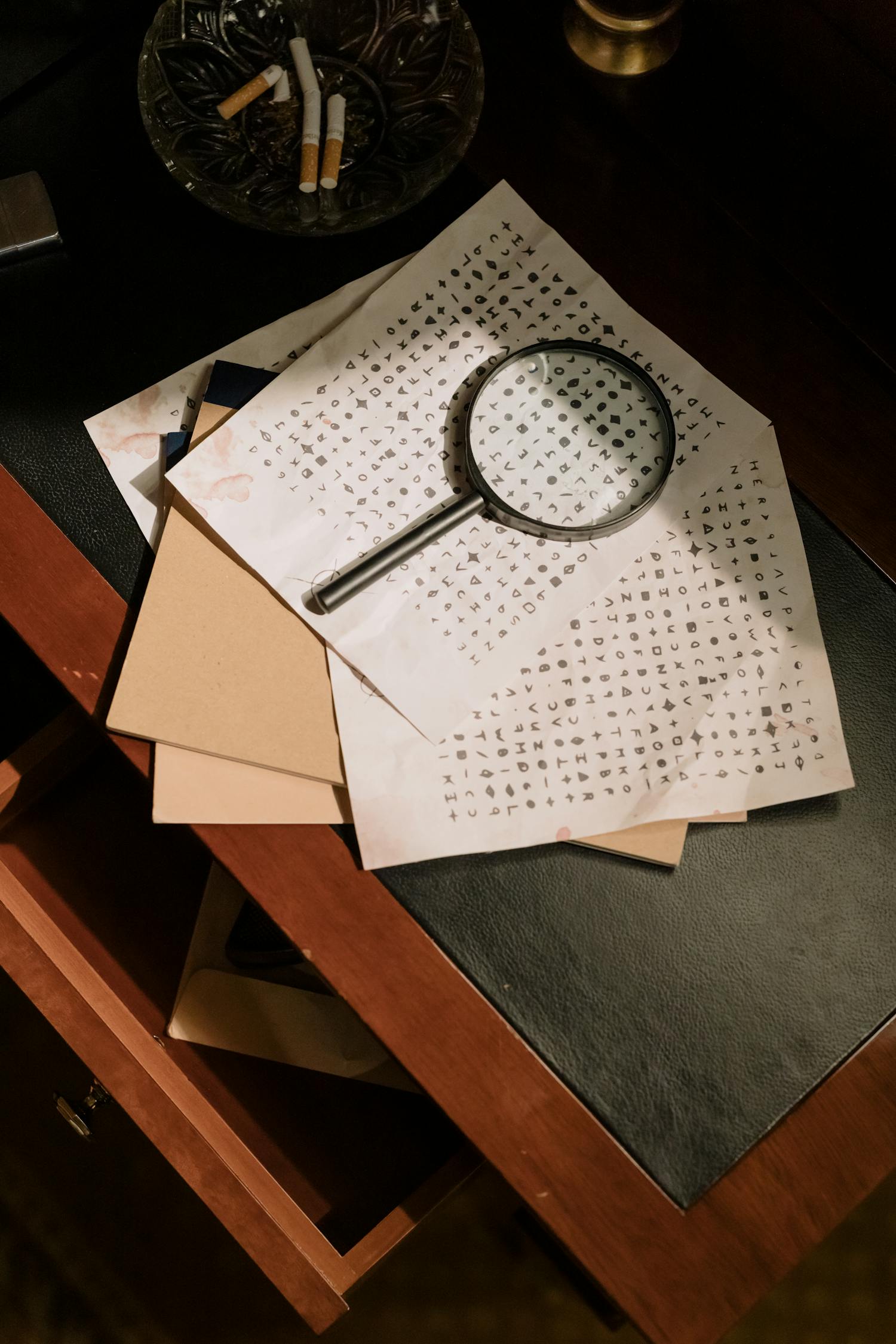 Photo Of Cryptic Character Codes And Magnifying Glass On Table Top Photo Of Cryptic Character Codes And Magnifying Glass On Table Top