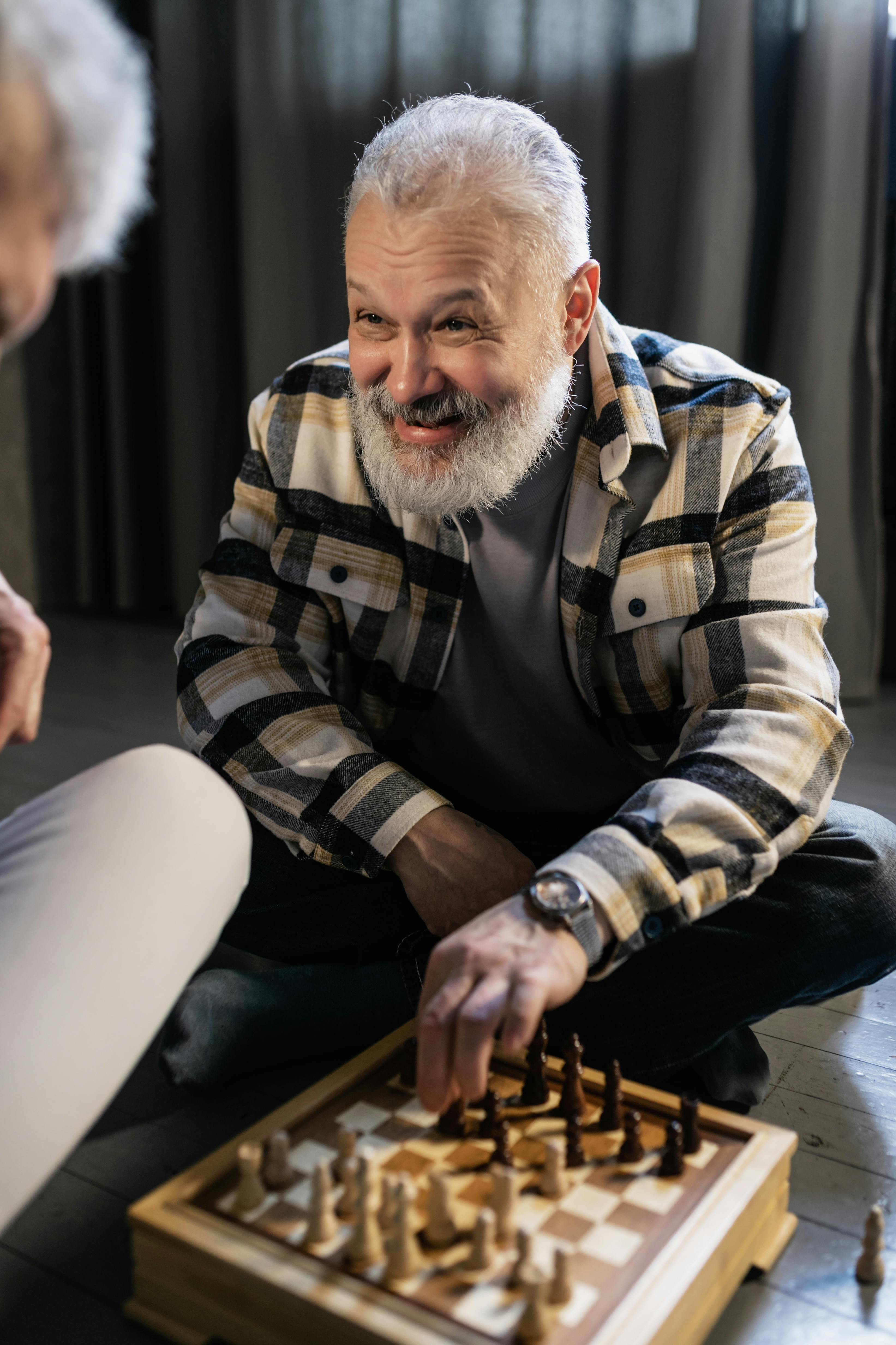 Elderly Man Smiling while Playing Chess · Free Stock Photo