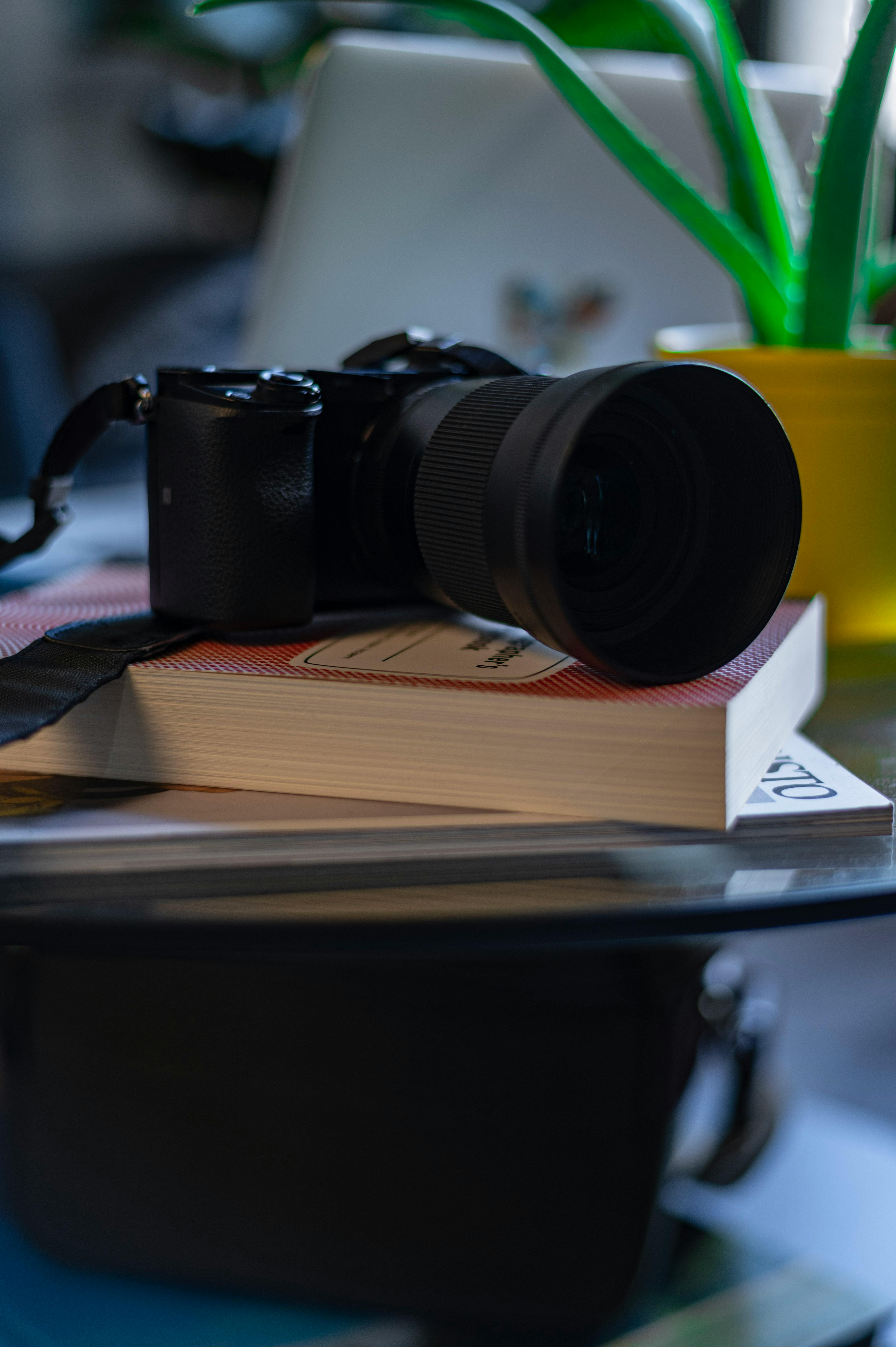 Close-Up Shot of a Black Camera on the Book · Free Stock Photo