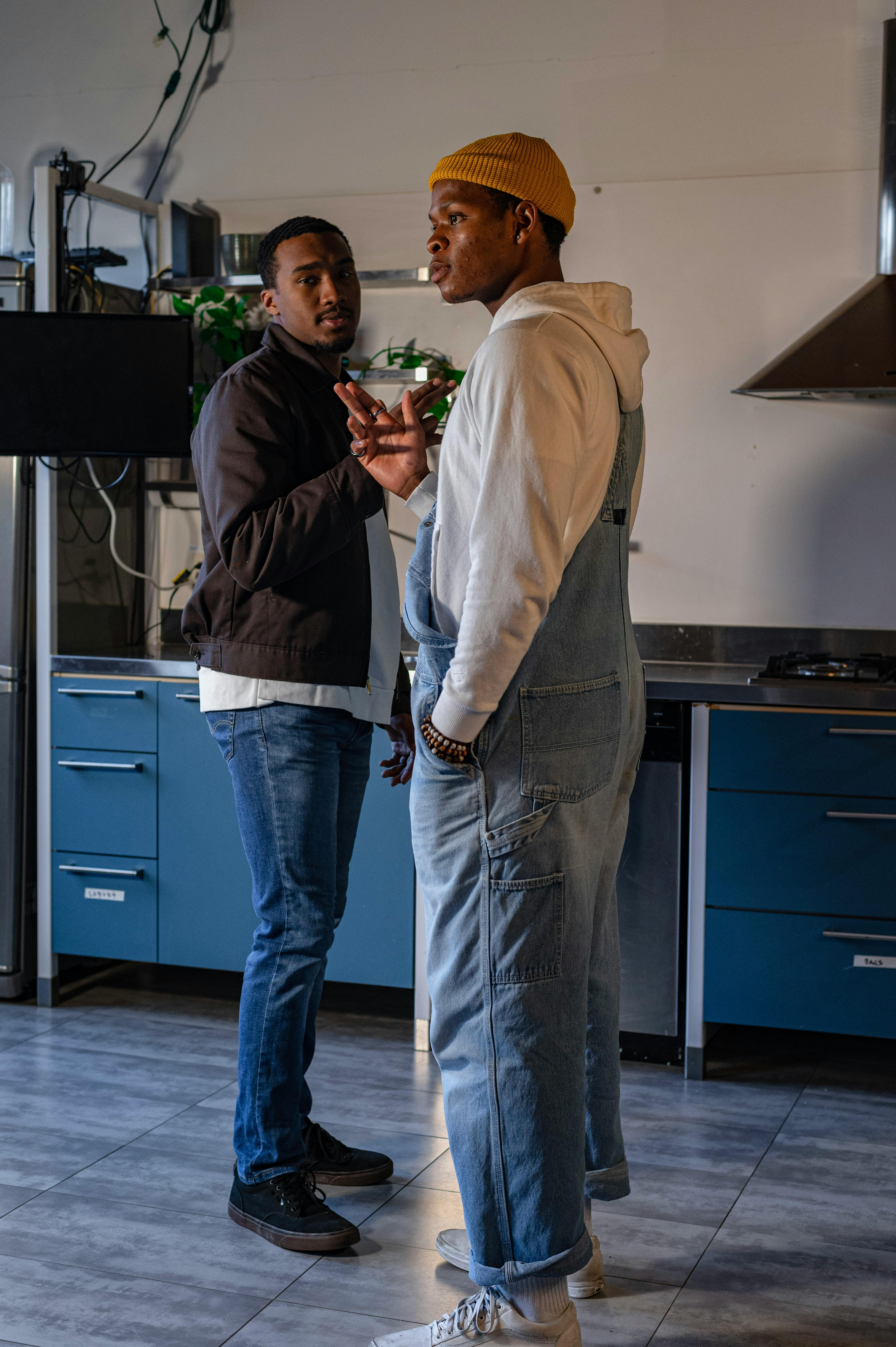 Young Men Standing Indoors Talking · Free Stock Photo