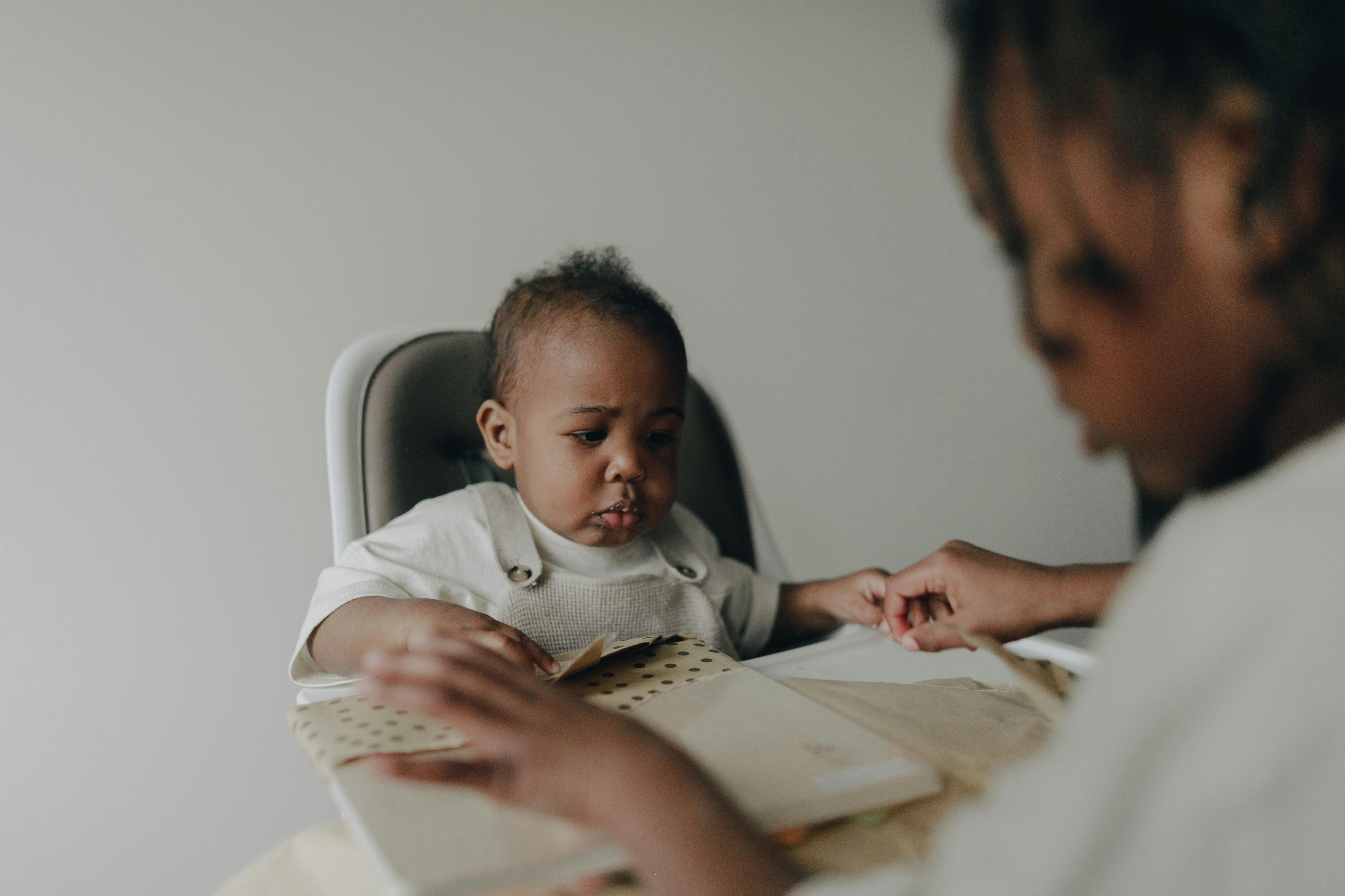 Sibling Helping a Baby to Unwrap a Birthday Present · Free Stock Photo