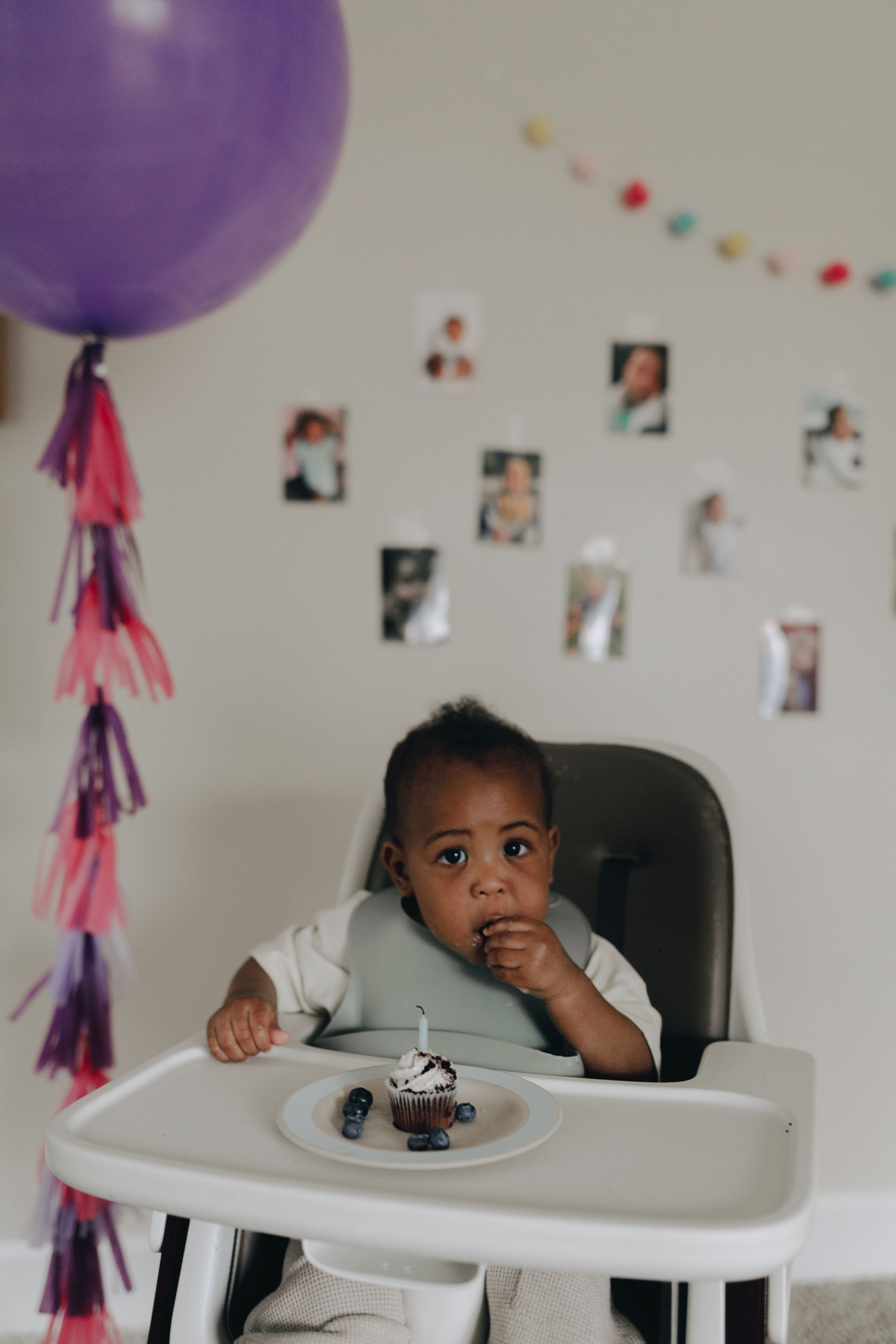 Baby Sitting in a High Baby Chair and Eating a Cupcake at the First ...