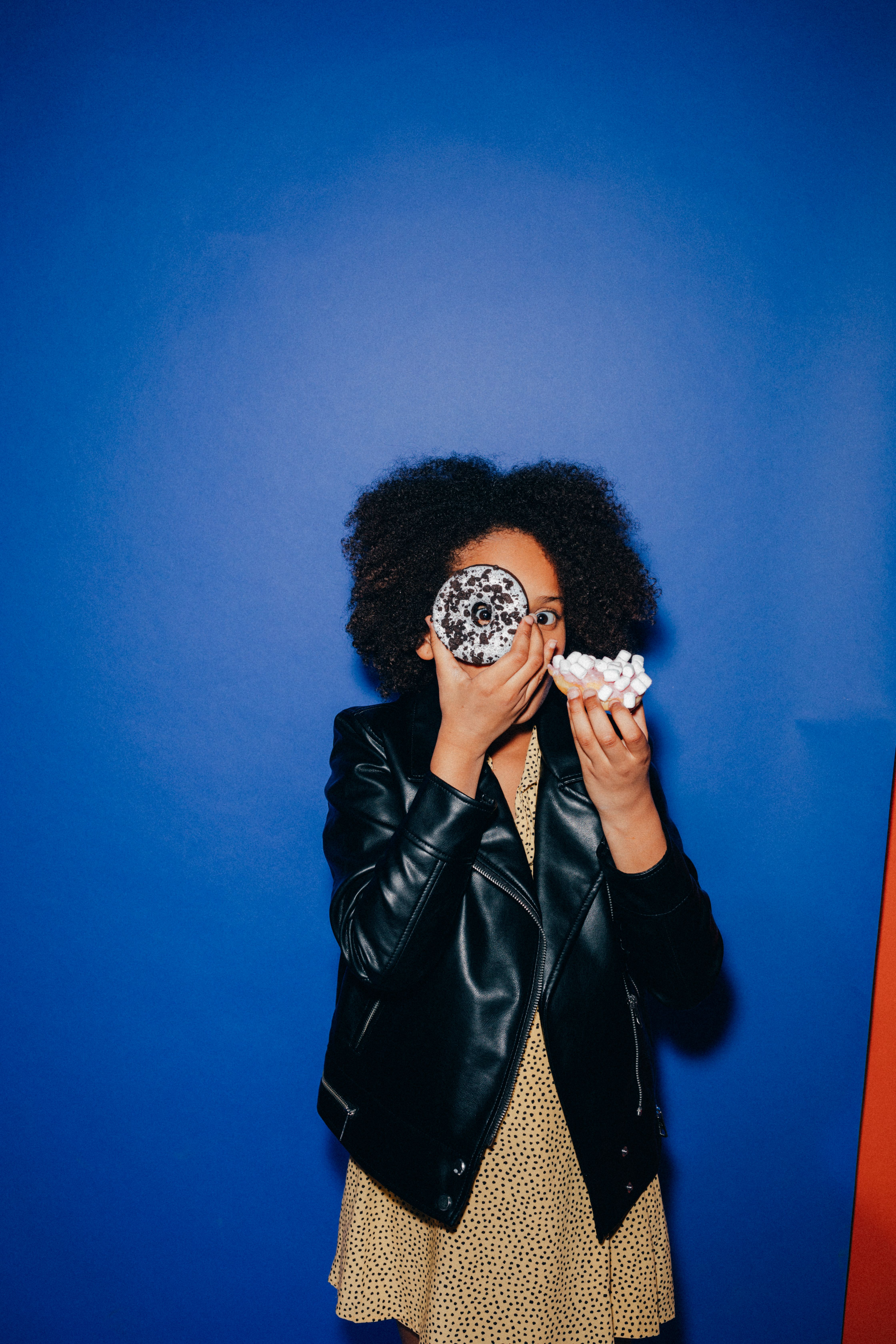 Girl Wearing a Leather Jacket Holding Doughnuts · Free Stock Photo