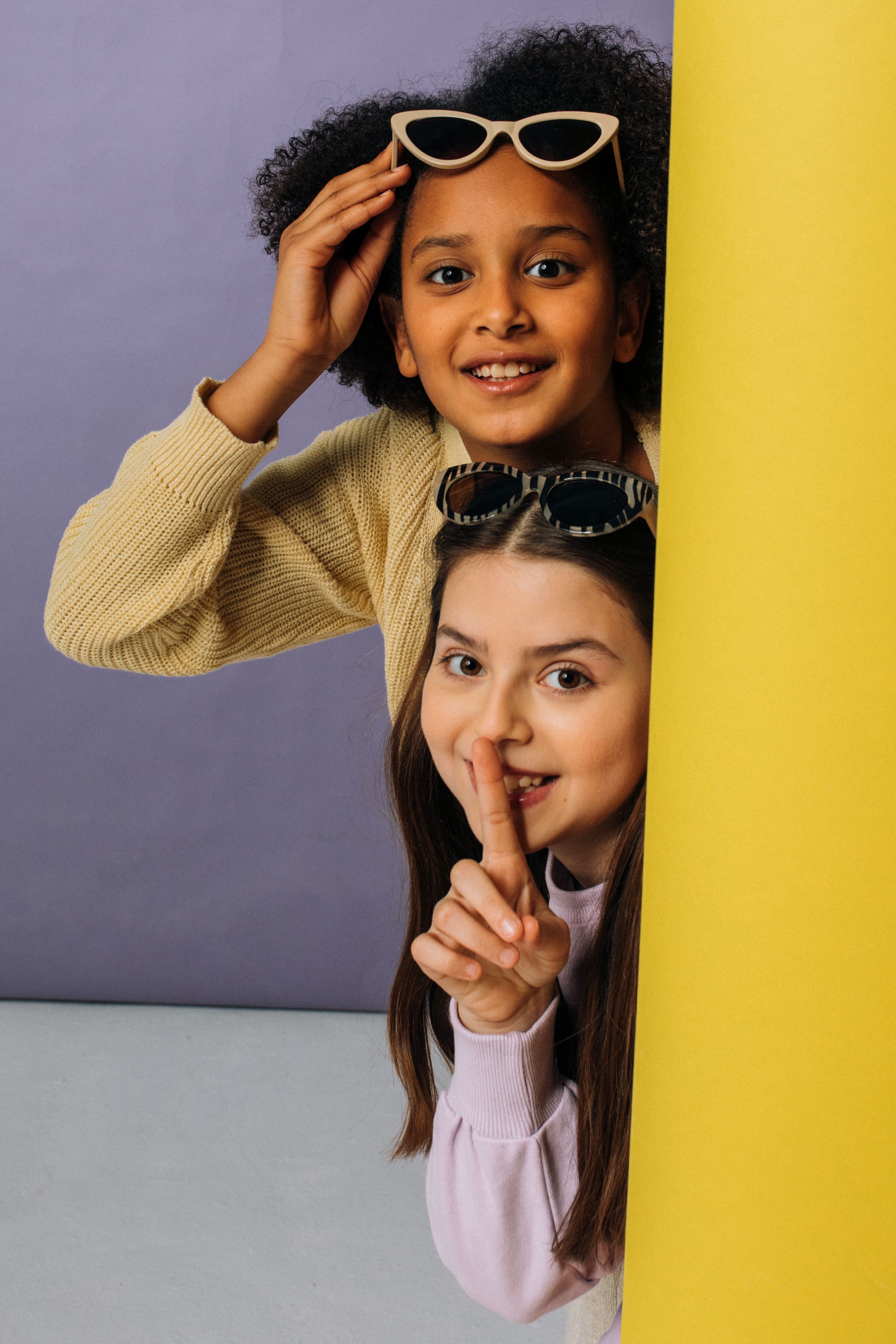 Girls Behind a Yellow Backdrop · Free Stock Photo
