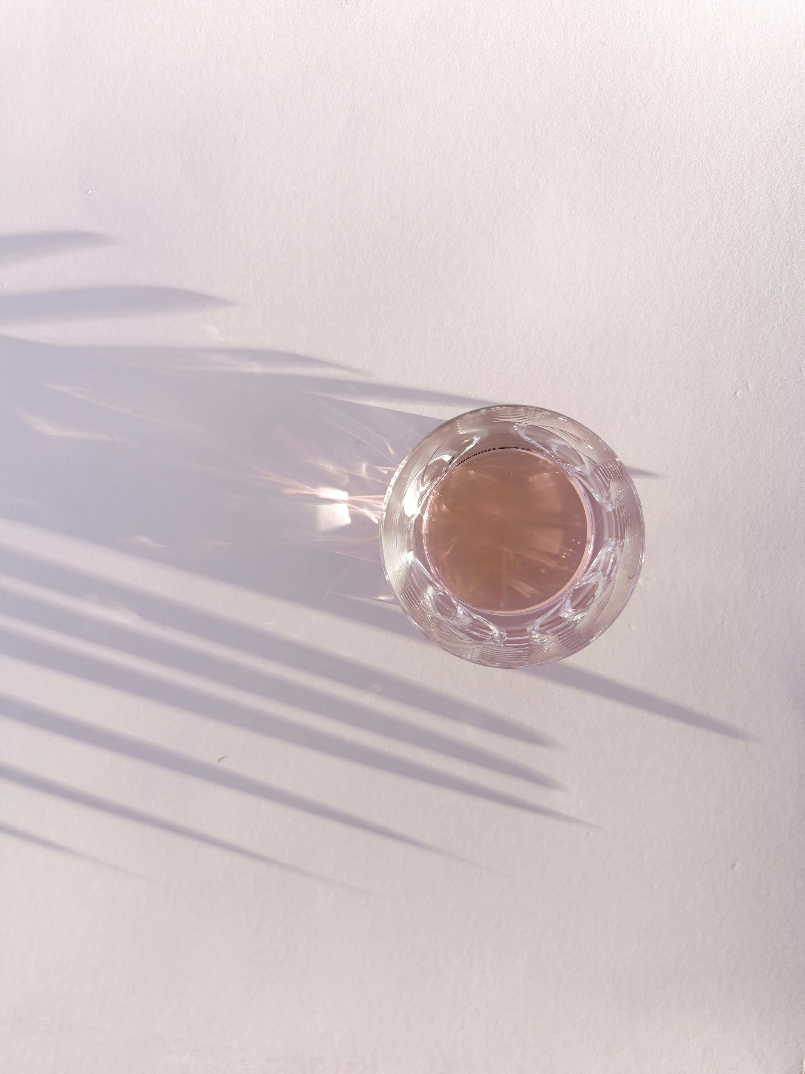 Small fragile glass balls with shadows on white table in daylight ...